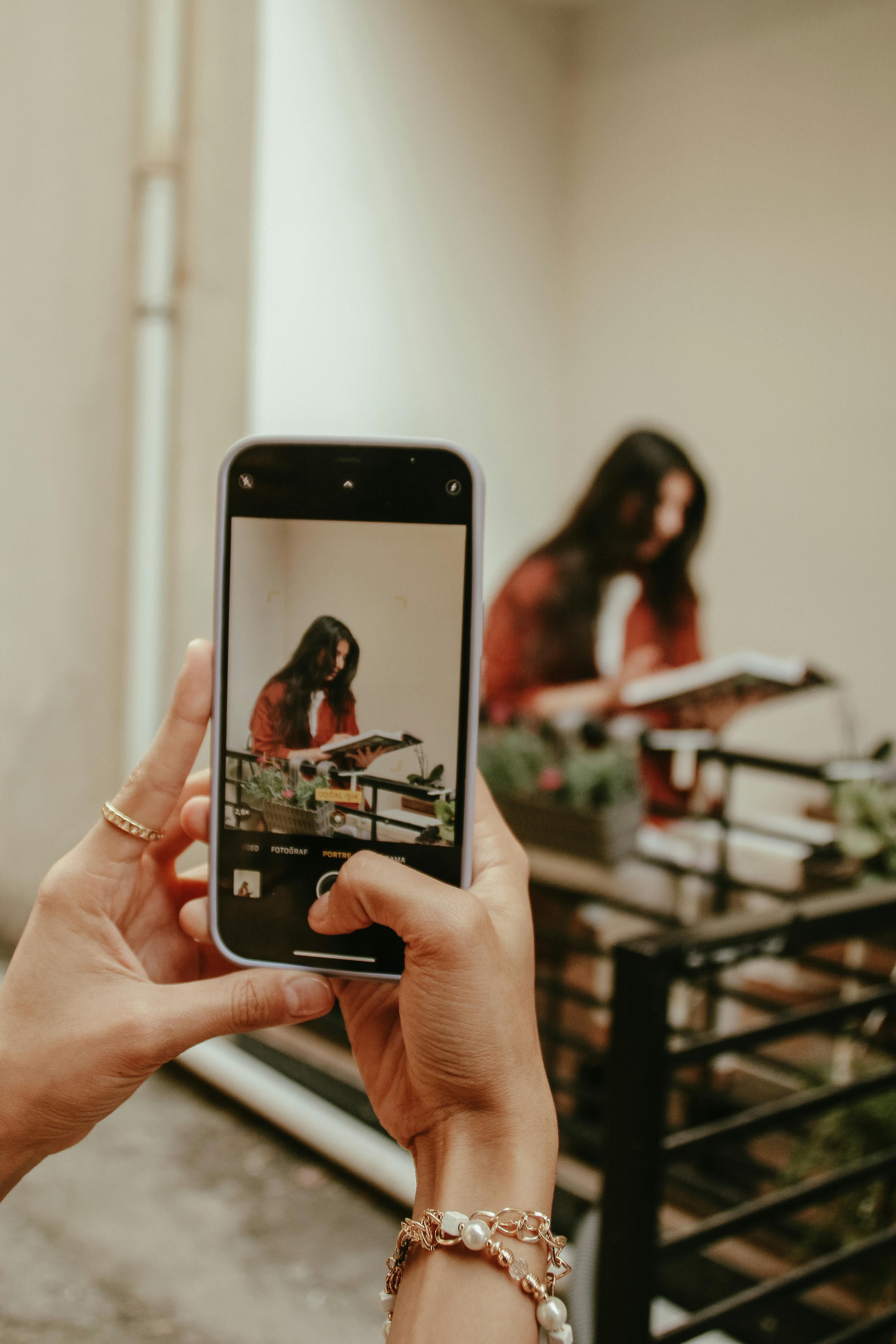 Hands of a Woman Photographing a Long-Haired Brunette with a Smartphone ...