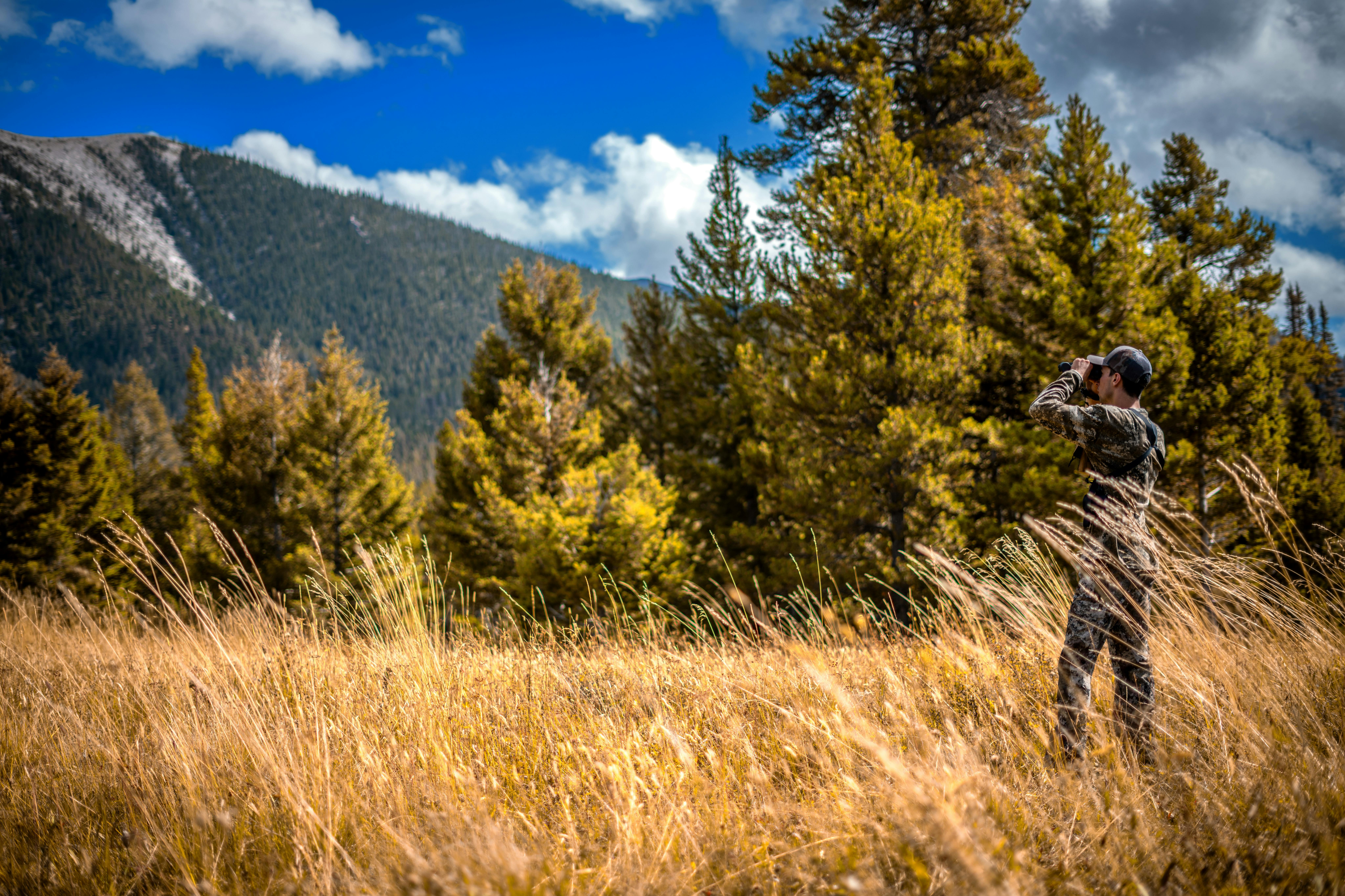 Man in Camouflage Clothes Looking at the Mountains Through Binoculars ...