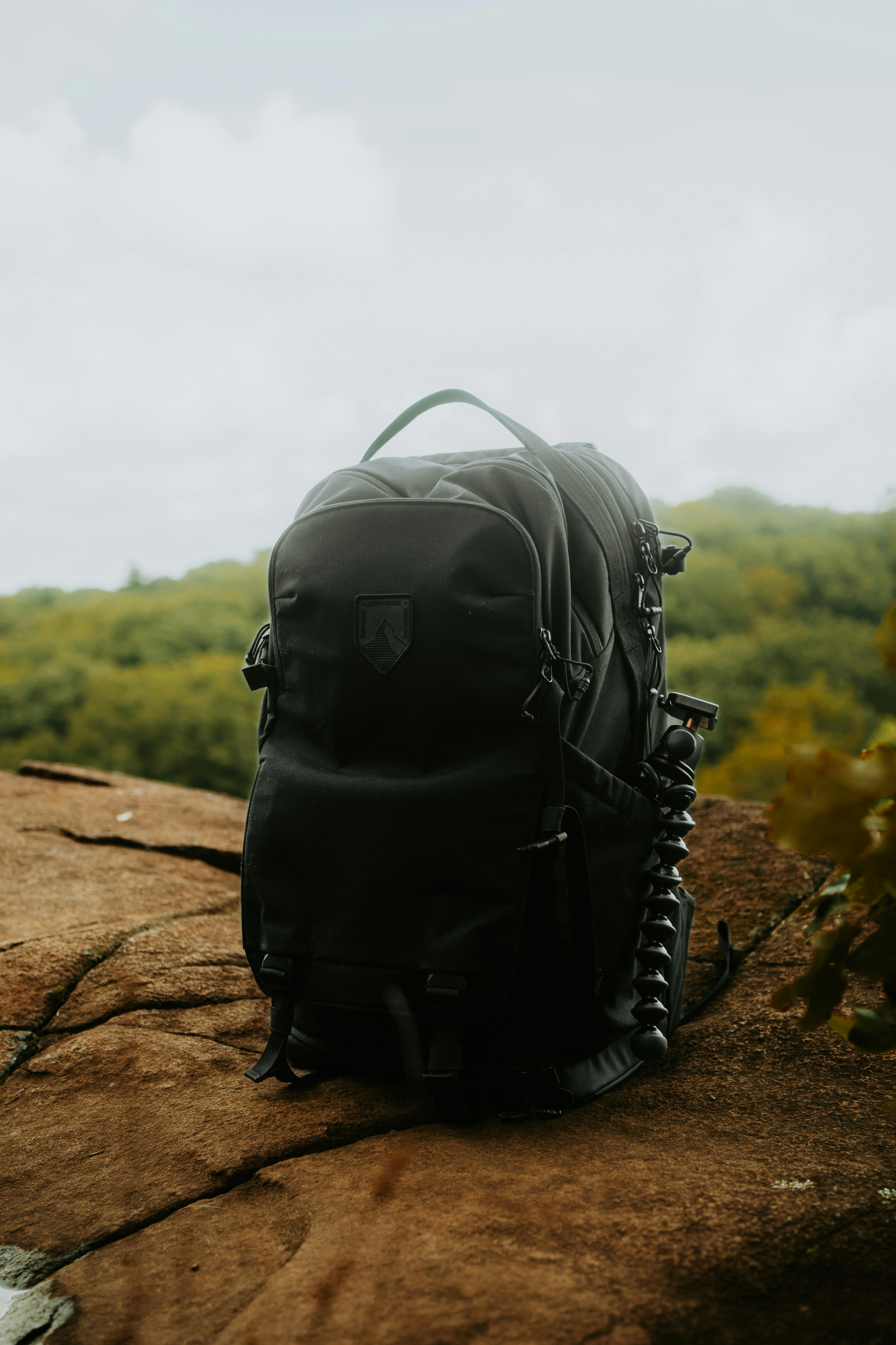 A Backpack Standing on a Rock · Free Stock Photo