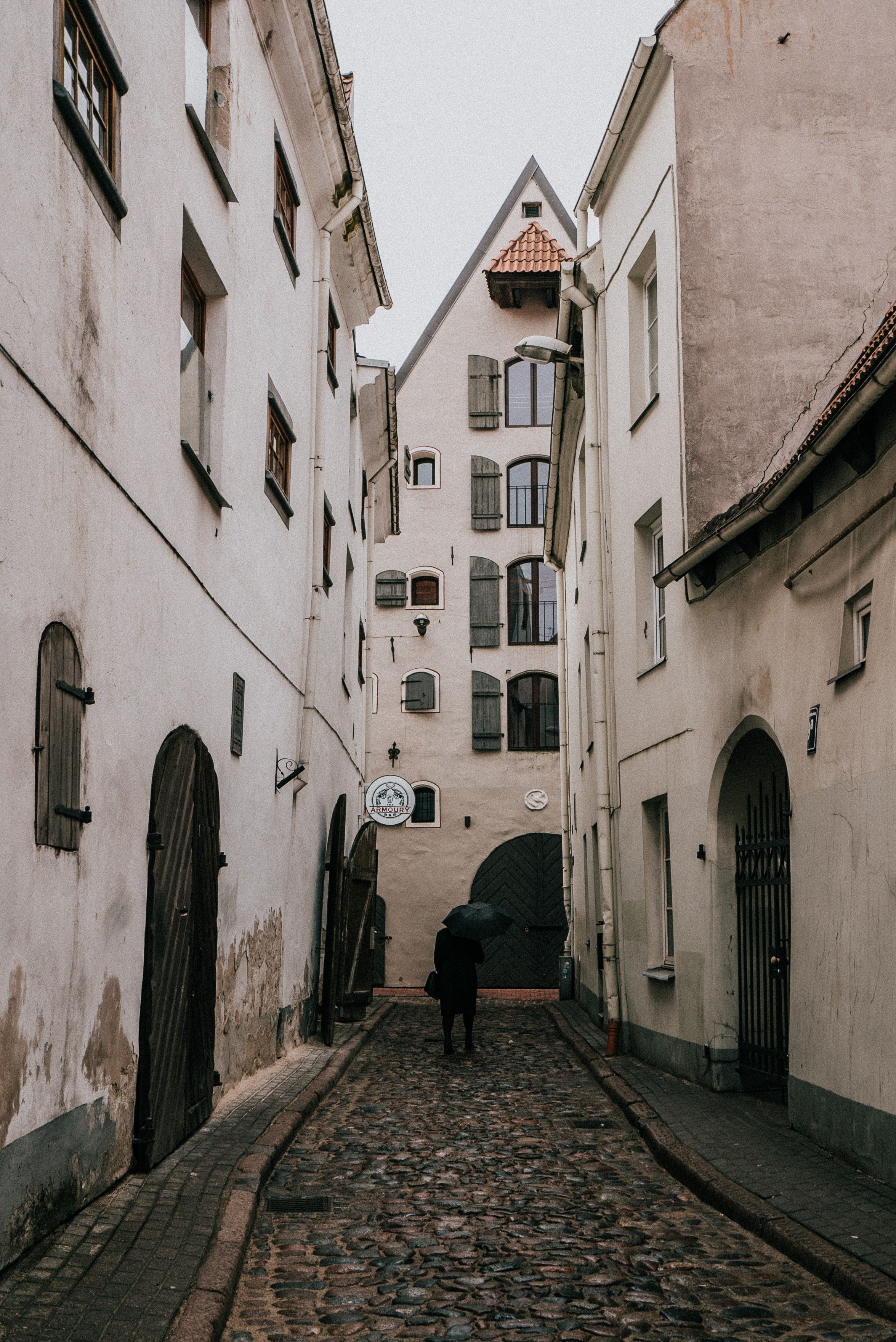 A person walking down a narrow street in tallinn, estonia · Free Stock ...