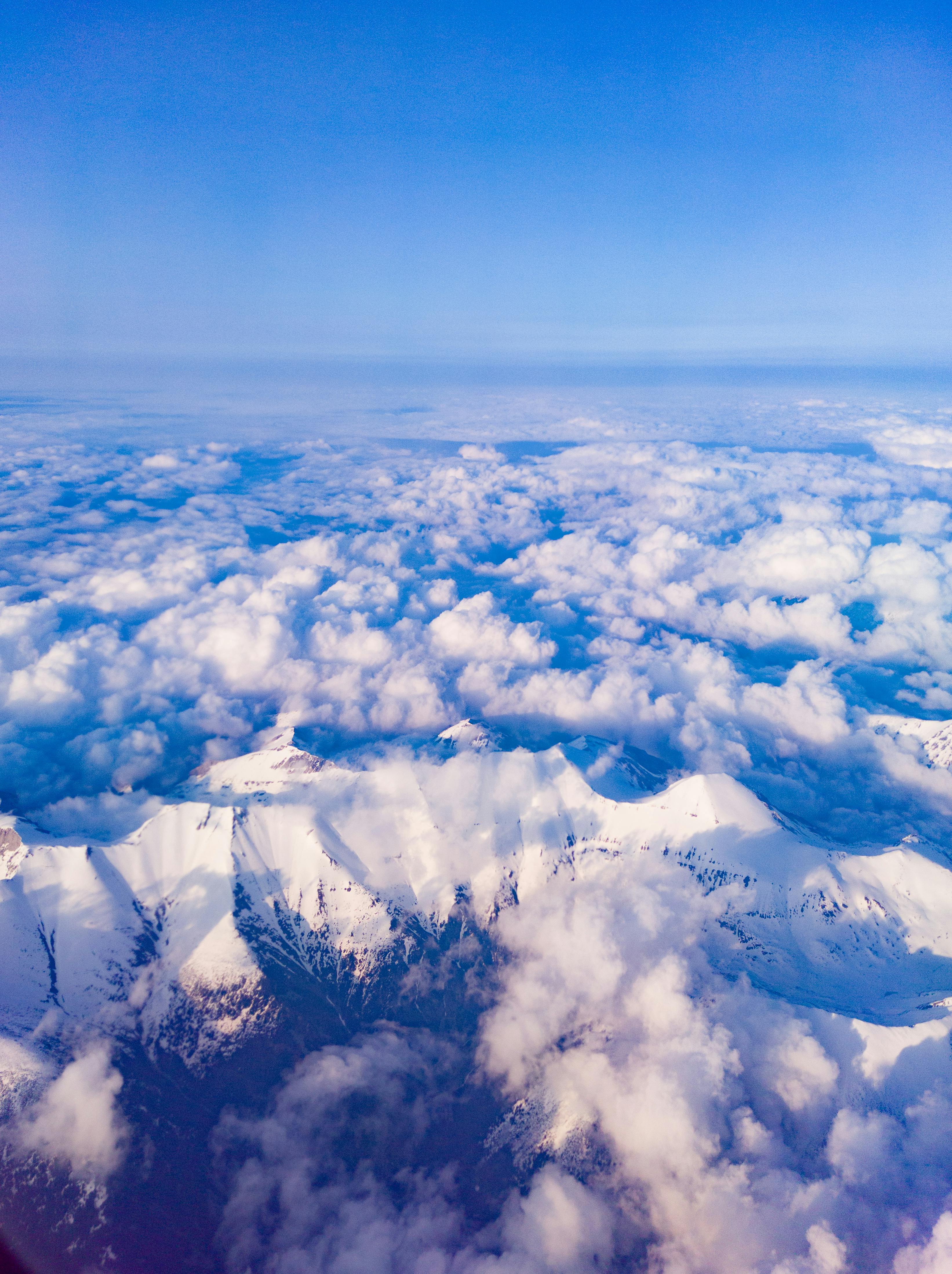 Scenic View of Clouds over Mountains Against Blue Sky · Free Stock Photo