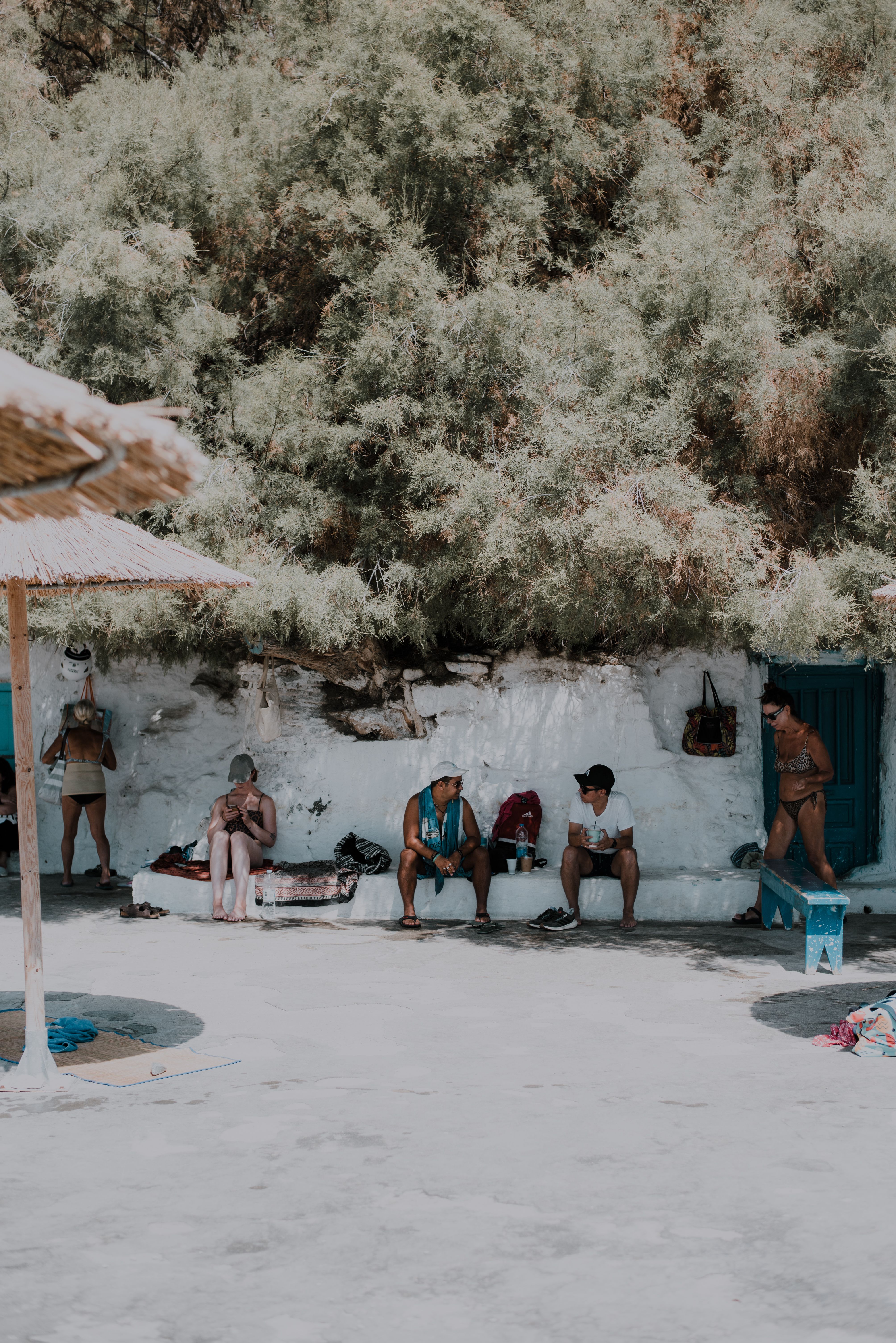 People Sitting by a Wall in a Shade near a Beach · Free Stock Photo