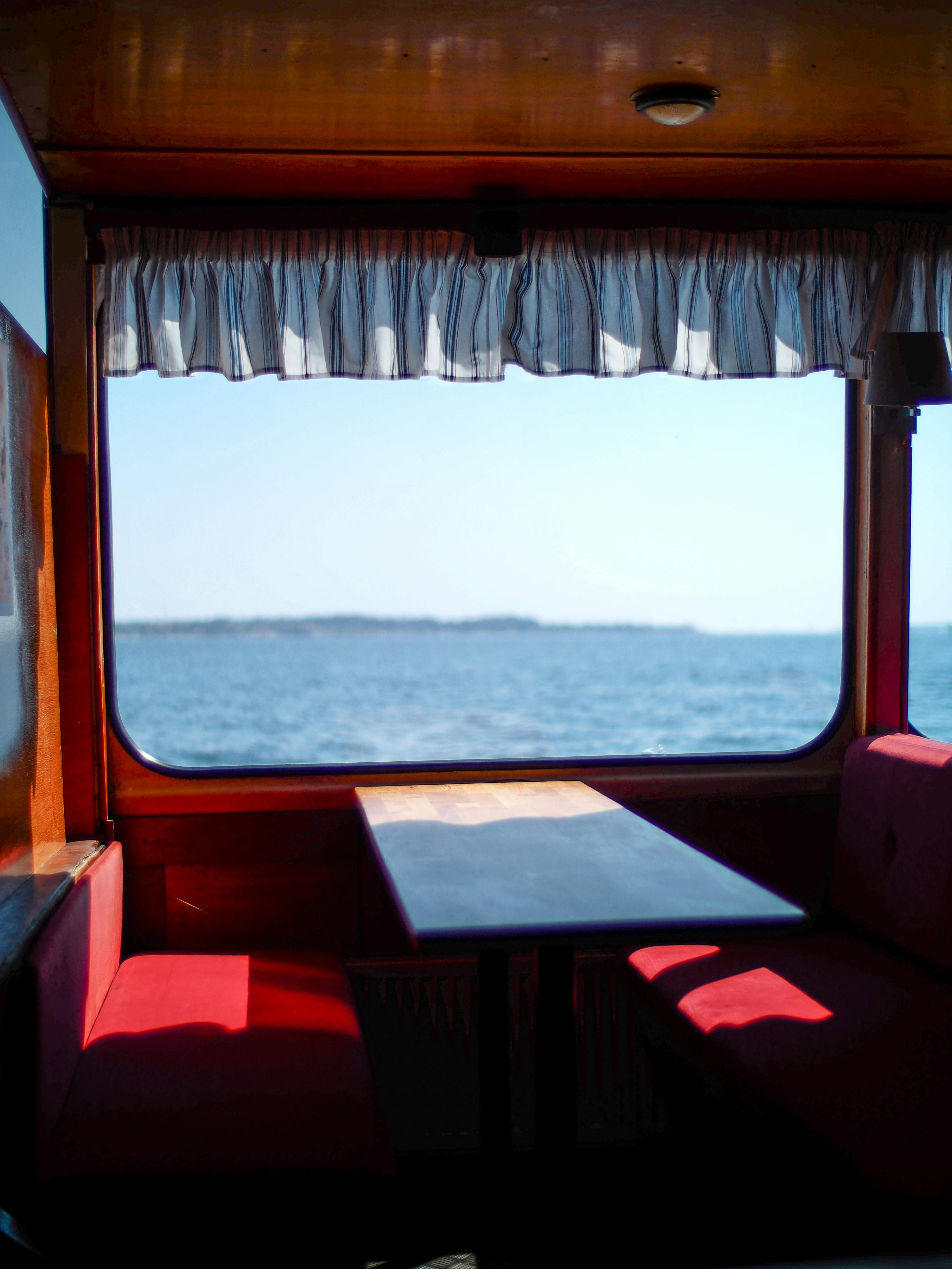 Table and Seats Near Window on Ship · Free Stock Photo