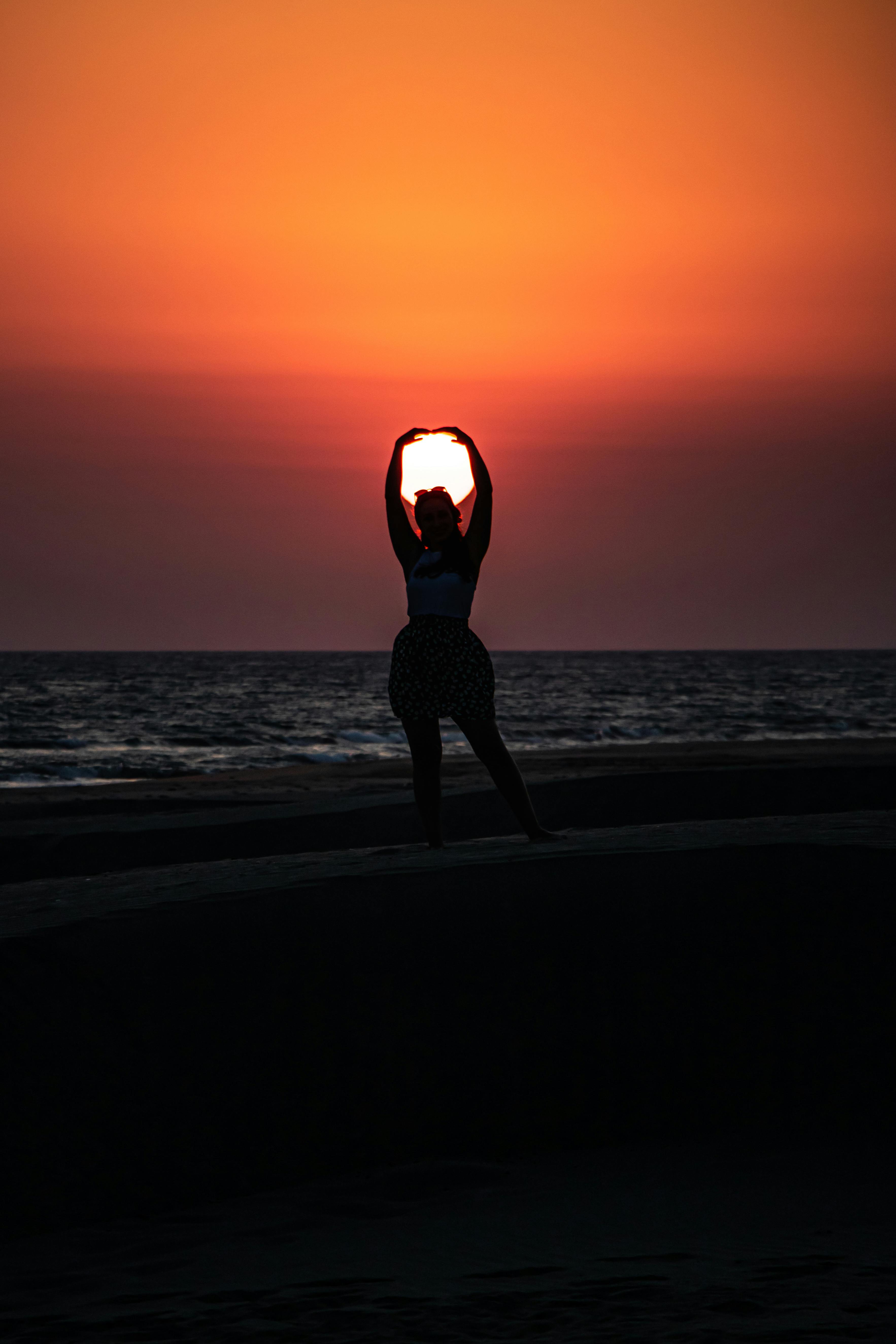 A Person Standing on a Beach at Sunset · Free Stock Photo
