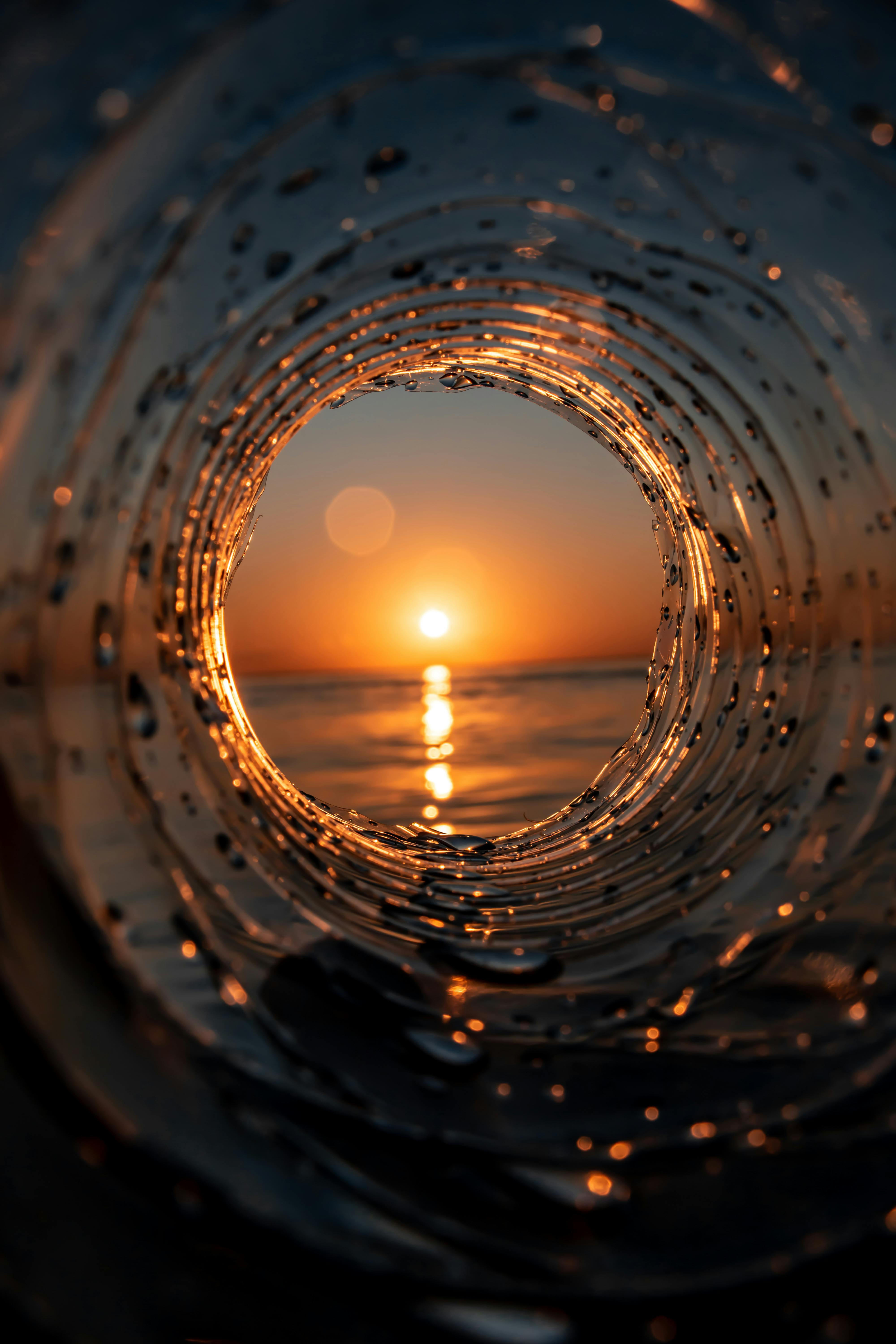 Sunset Sunlight over Water behind Pipe Hole · Free Stock Photo