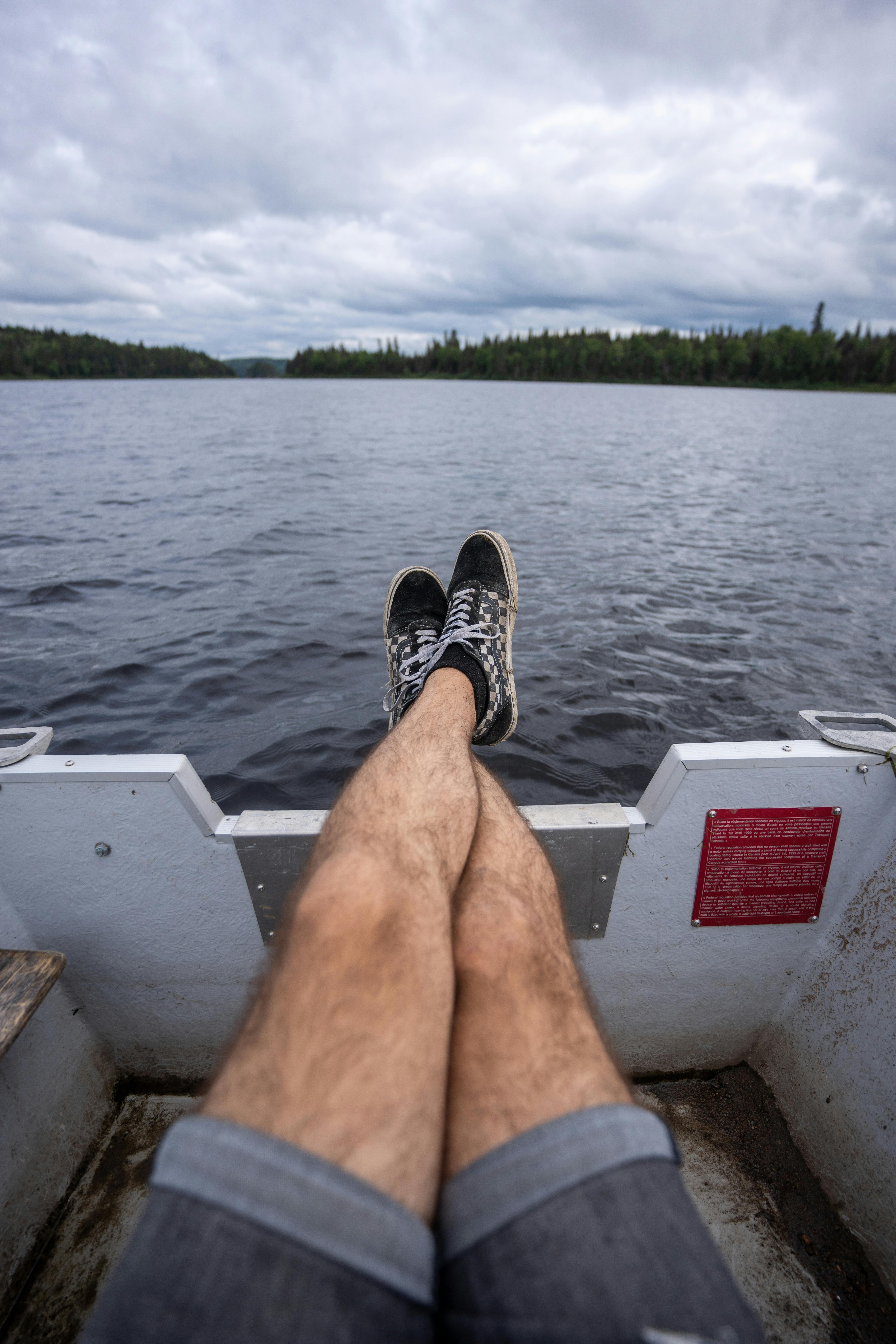 Legs of Man Sitting on Boat · Free Stock Photo