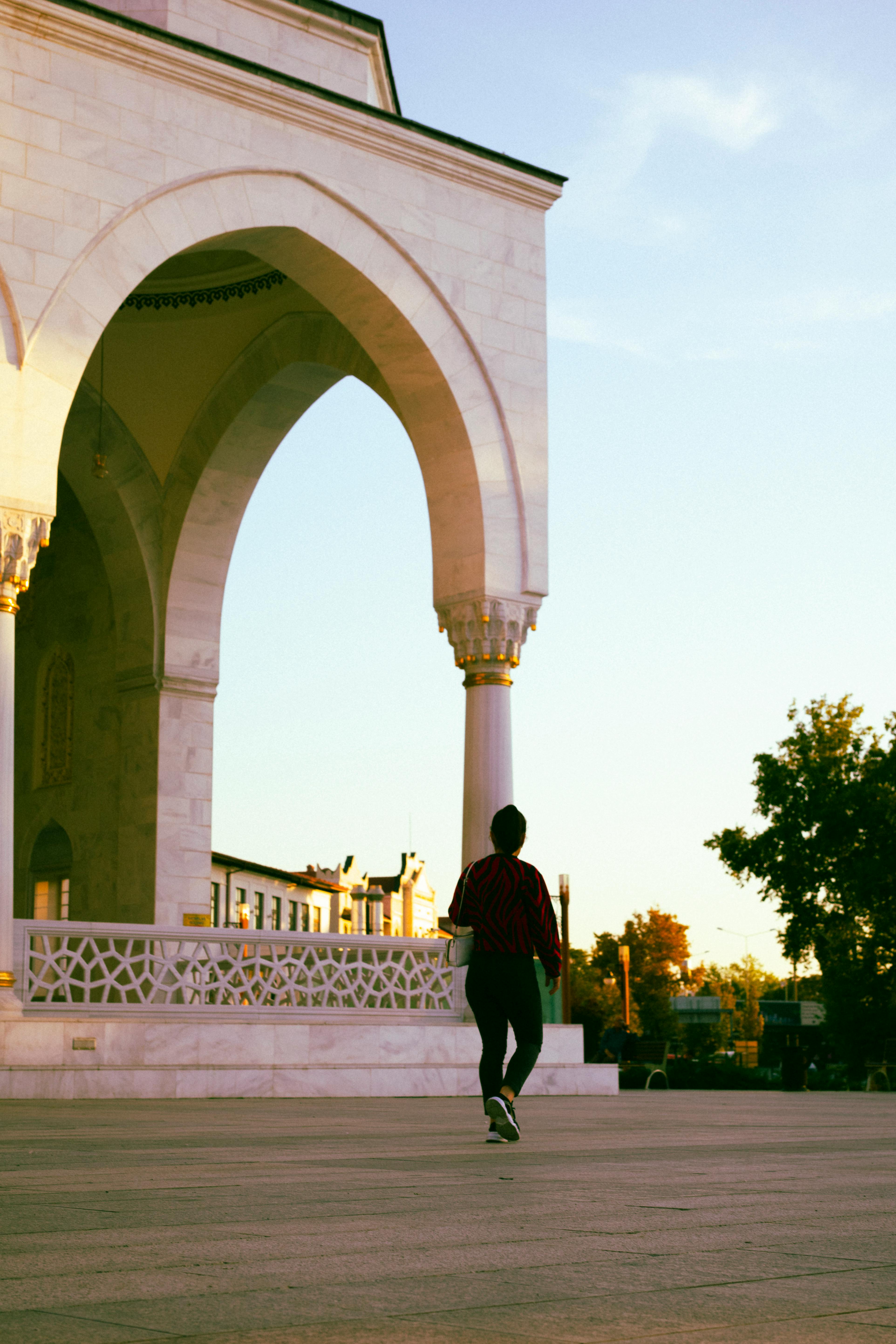 Woman Walking across Town Square at Sunset · Free Stock Photo