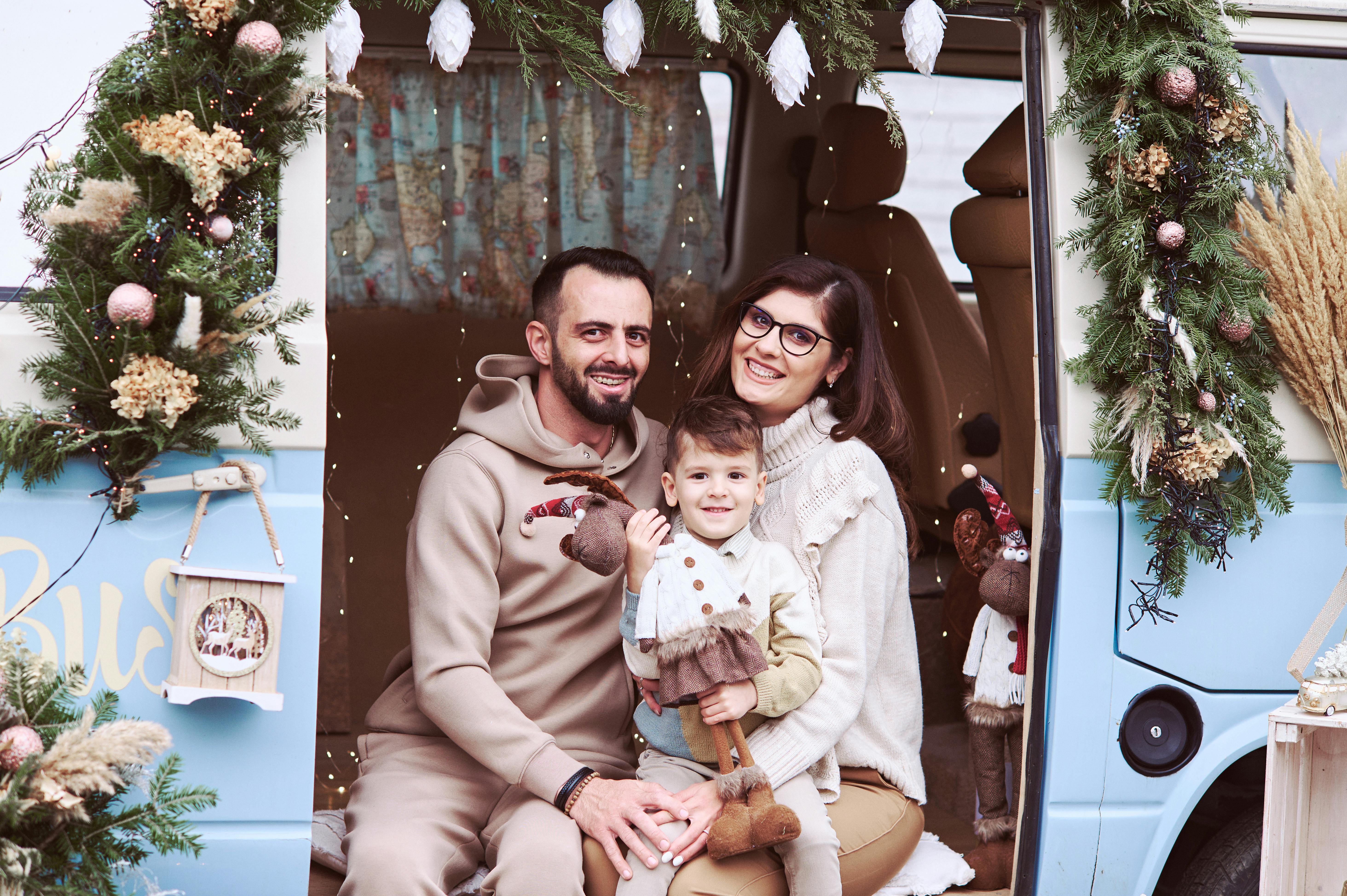 Family Posing in a Christmas Decorated Van · Free Stock Photo