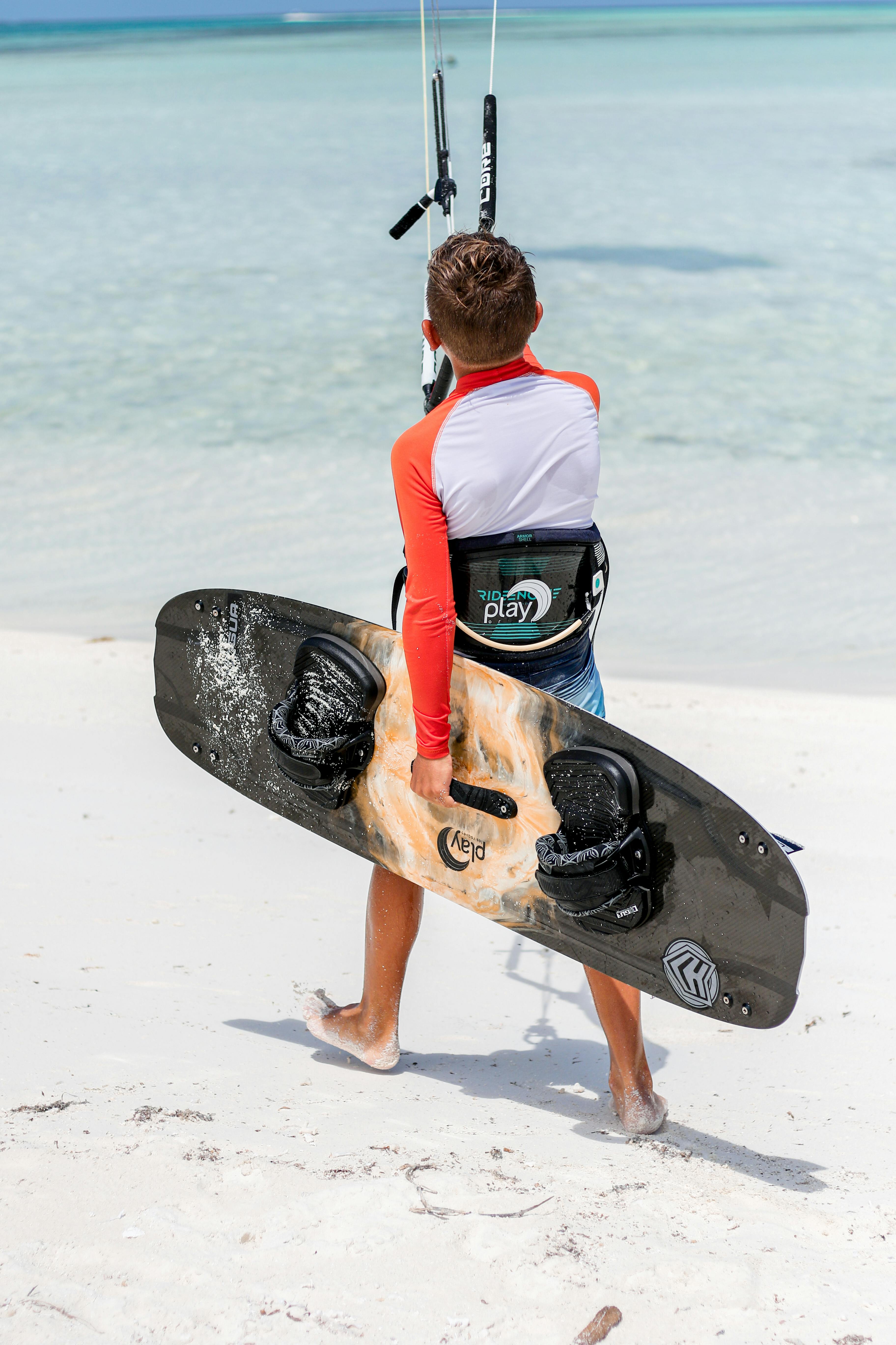 Surfur with a Surfboard Walking on the Beach · Free Stock Photo