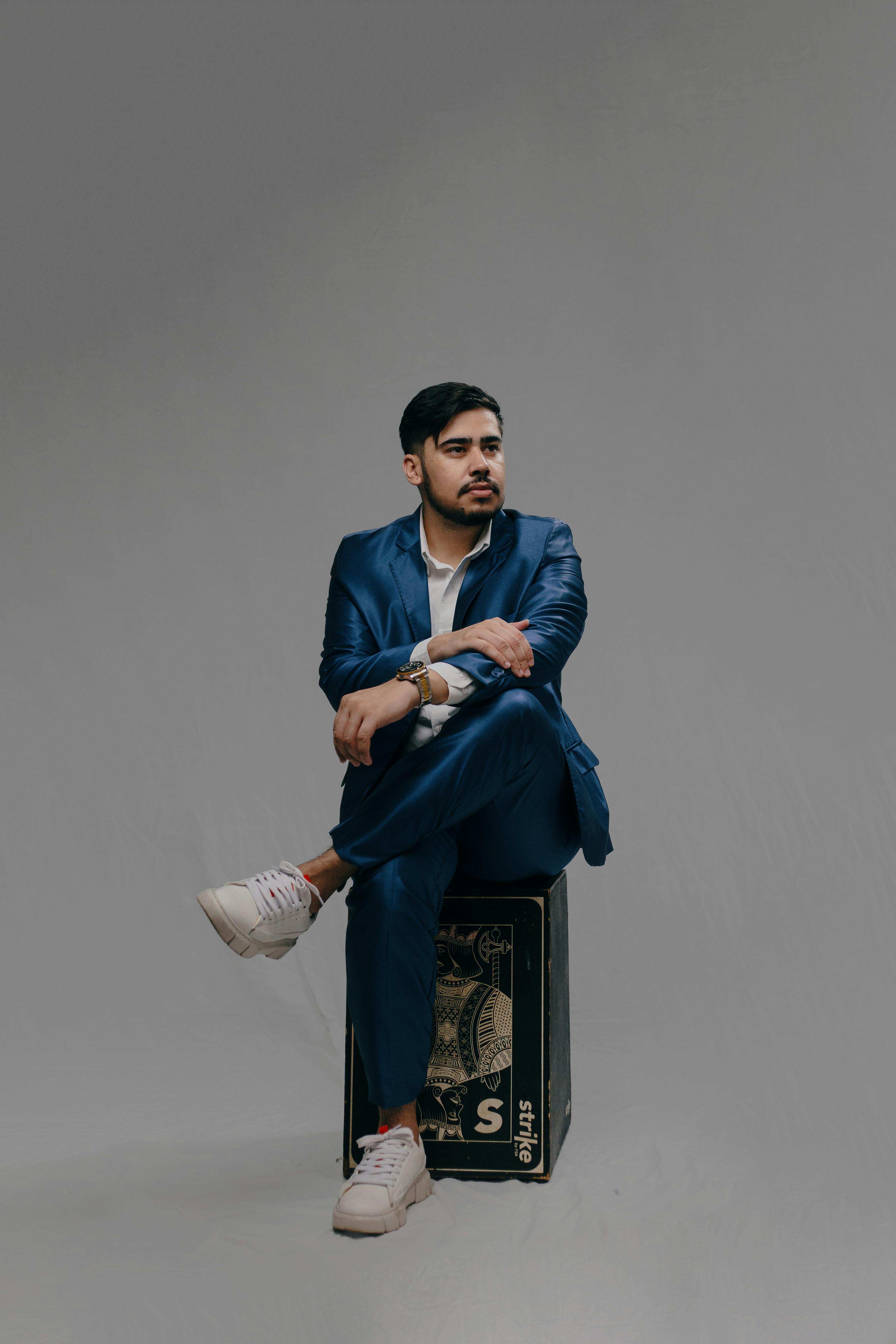 Man in Blue Suit Sitting and Posing on Box · Free Stock Photo