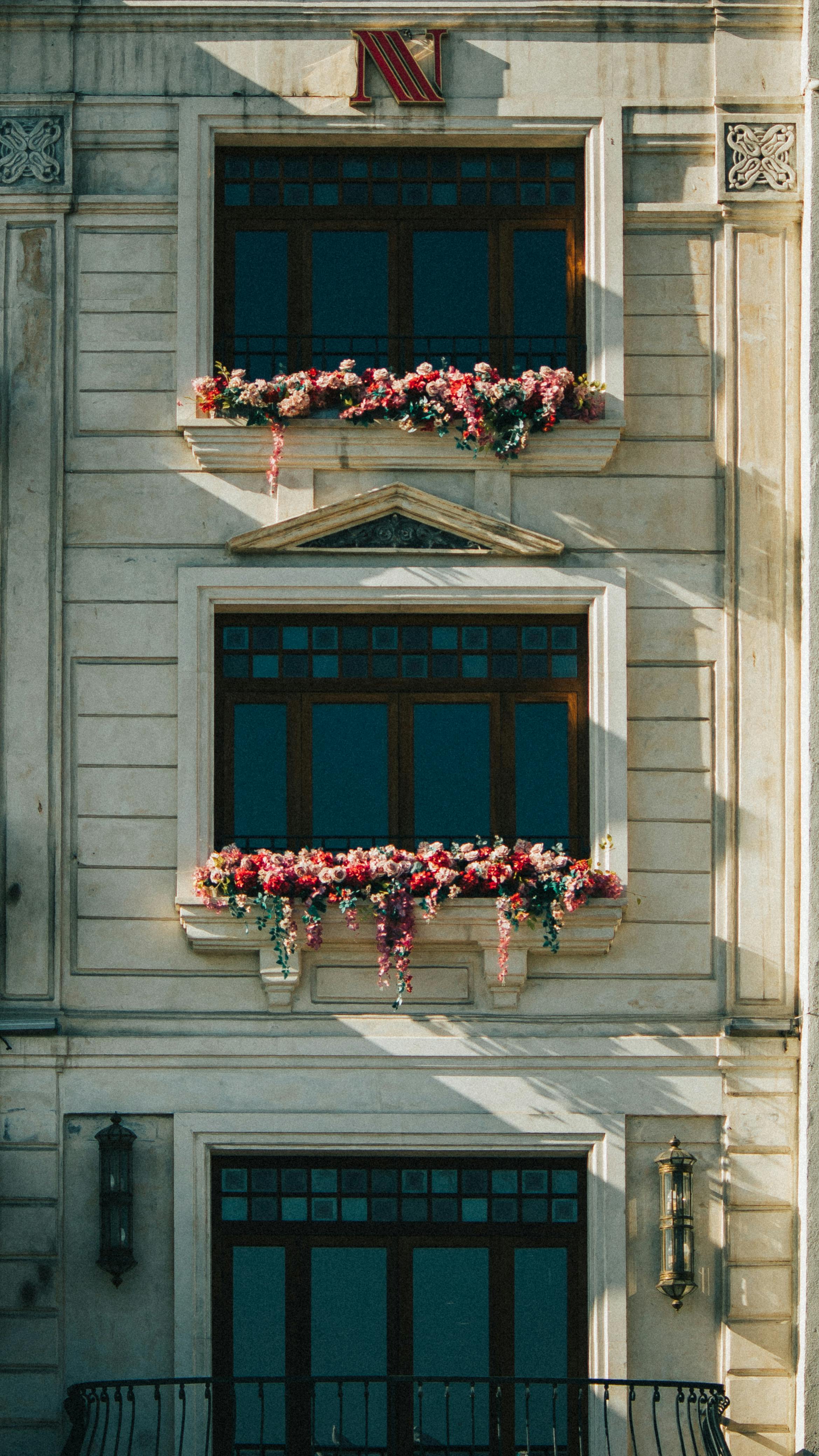 A building with flowers on the windows and balconies · Free Stock Photo