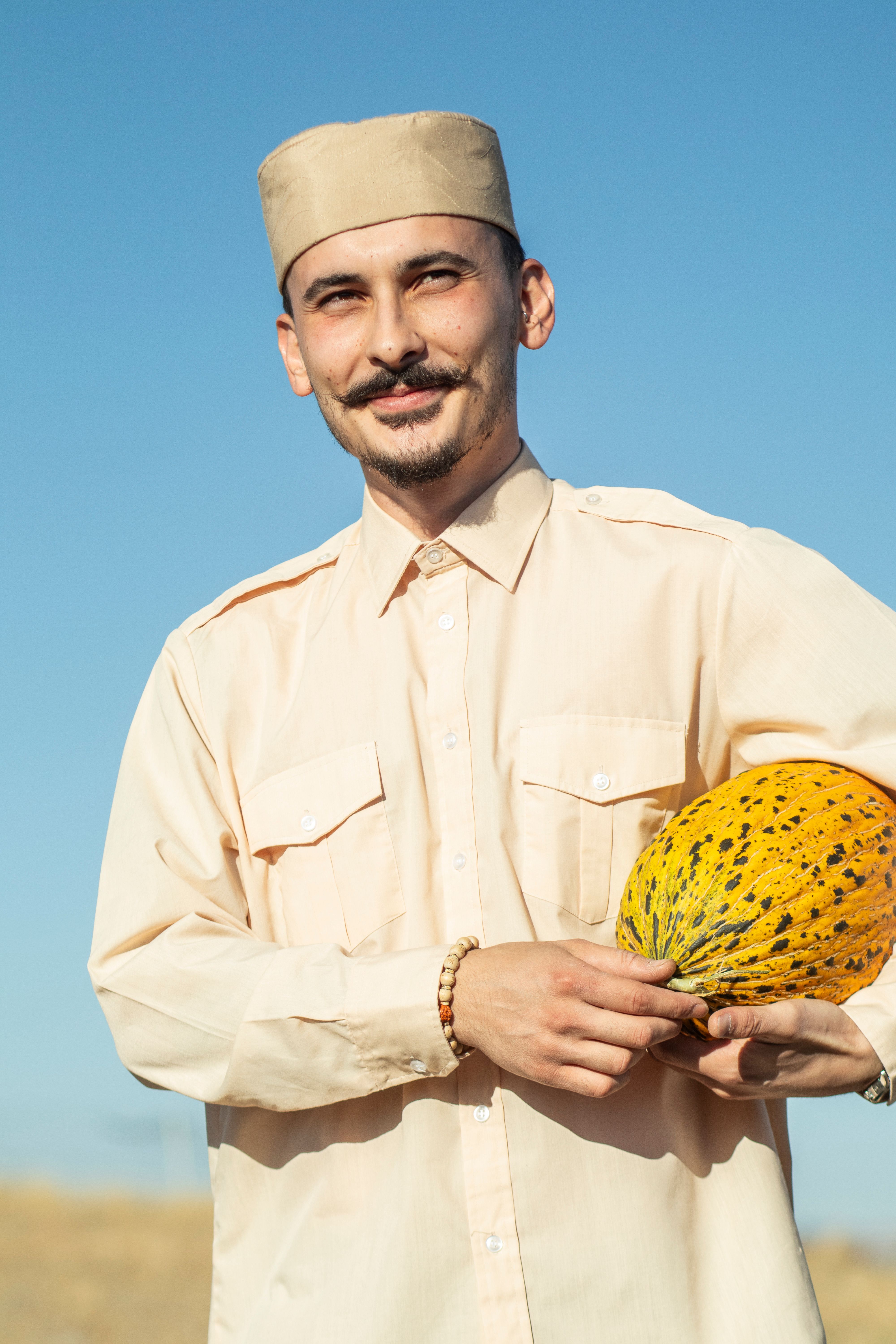 Smiling Man in Beige Kufi Holding Kirkagac Melon Under His Arm · Free ...