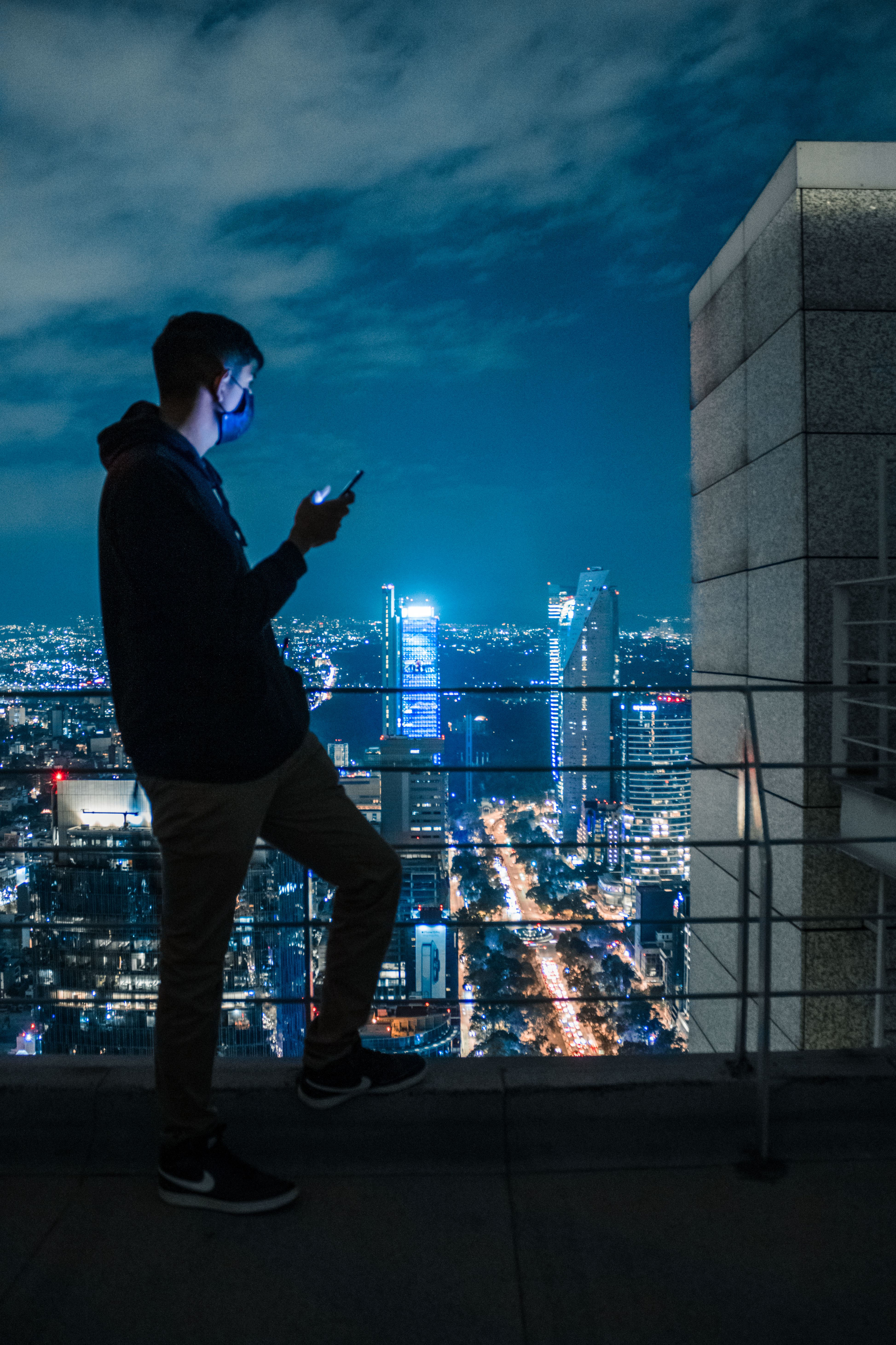 A Man Standing on a Terrace with View of Downtown Mexico City at Night ...