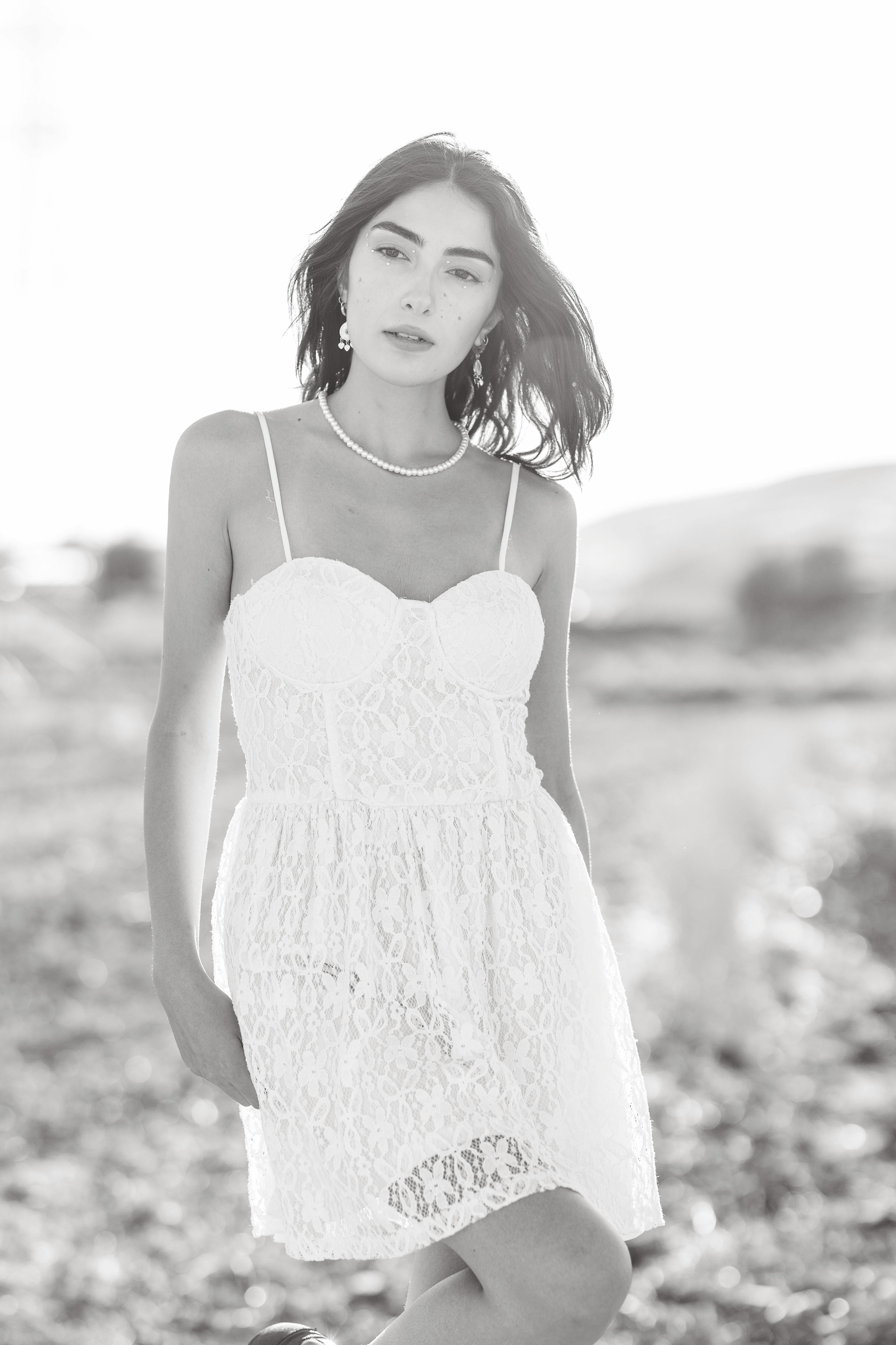Model with Flowing Hair in a White Summer Dress Wading in the Sea ...