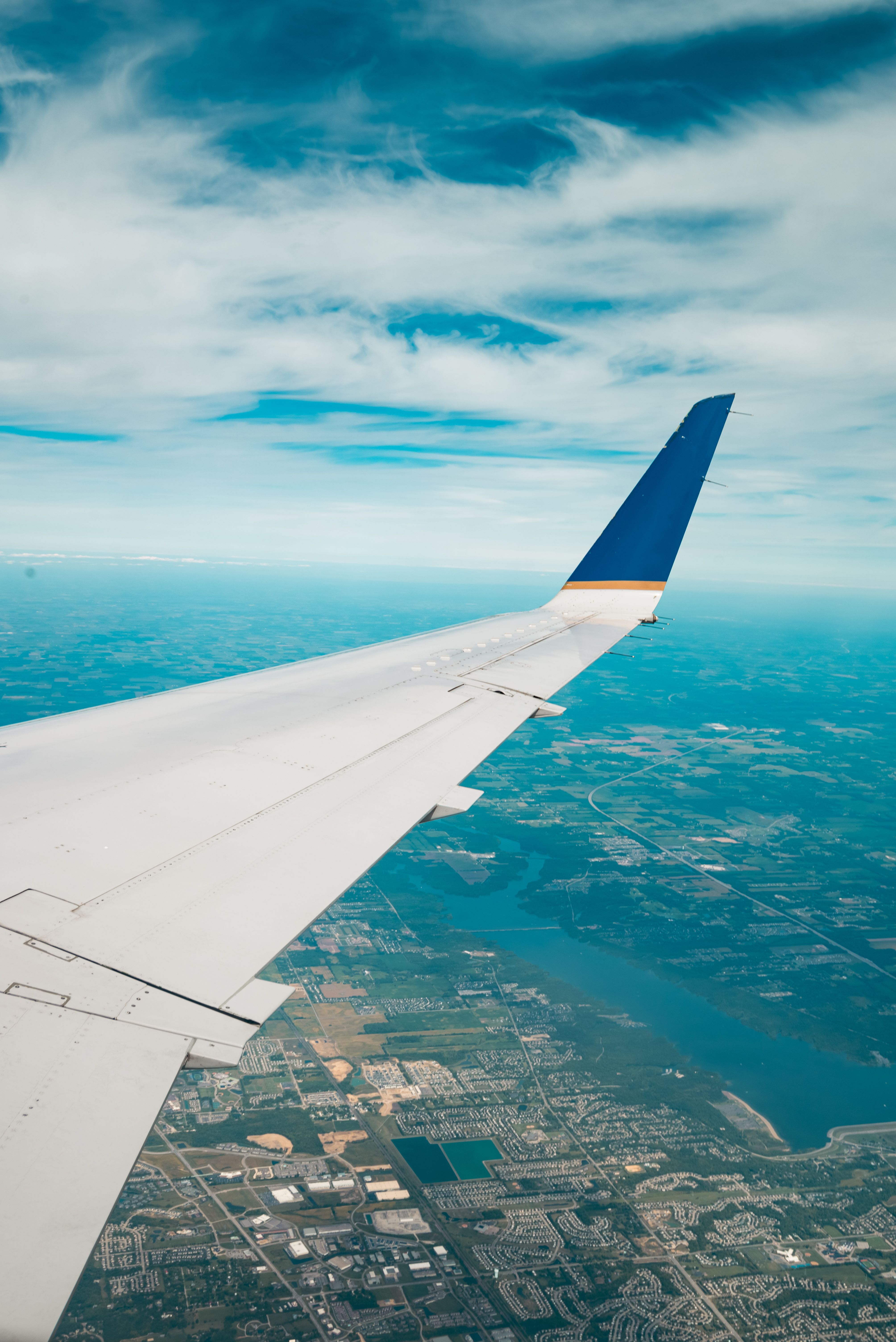 Wing of Airplane Flying over Town · Free Stock Photo