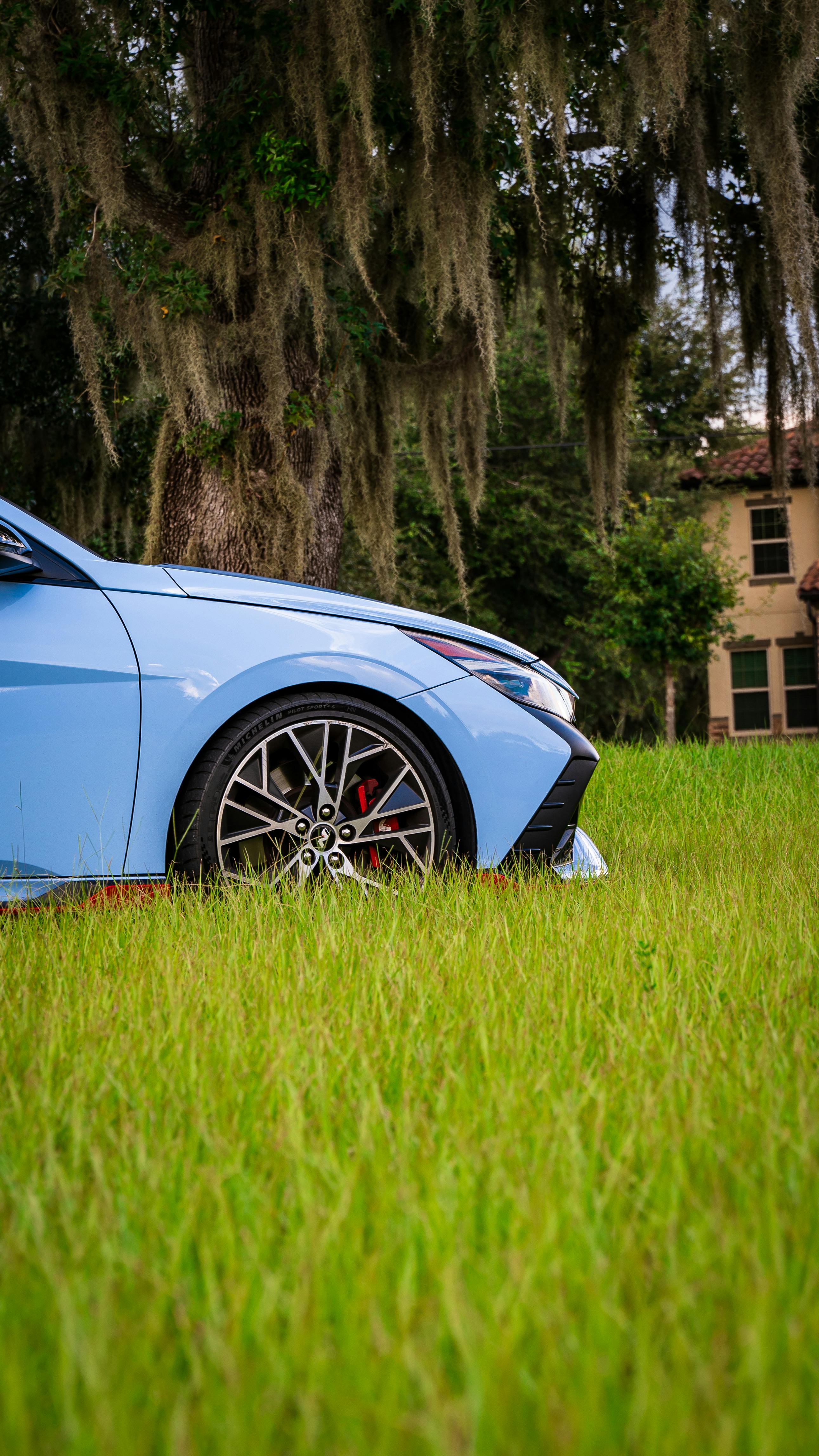 A Blue Hyundai Elantra Parked on a Grass Field · Free Stock Photo