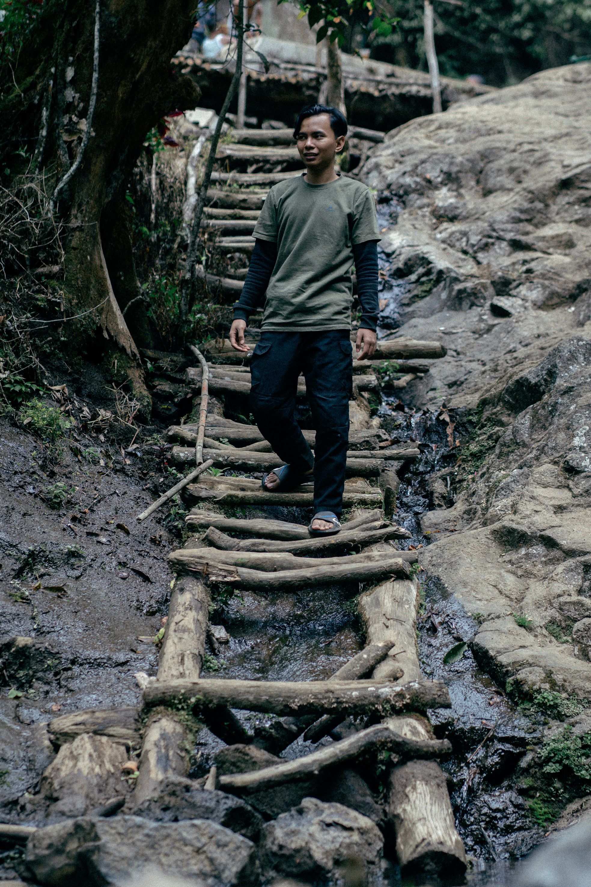 Young Man Walking on a Wooden Trail · Free Stock Photo