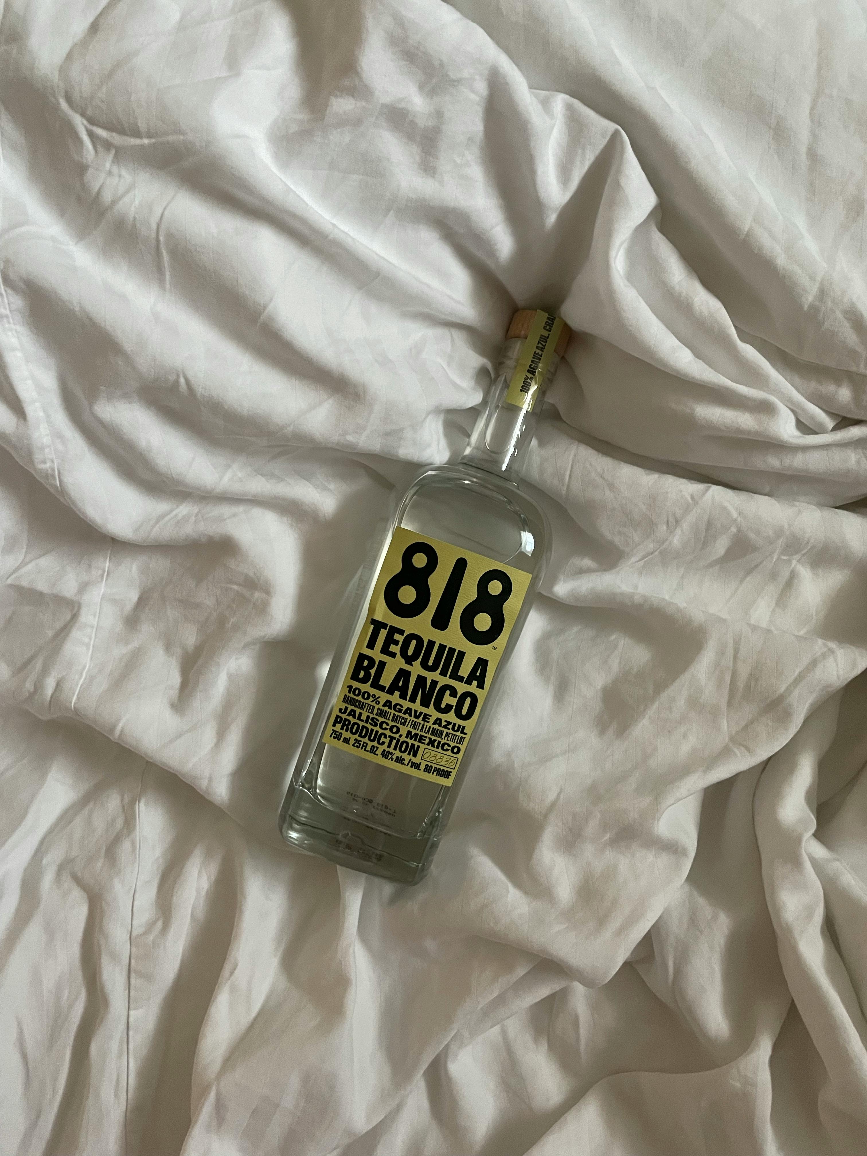 Bottle of Tequila on a Bed · Free Stock Photo