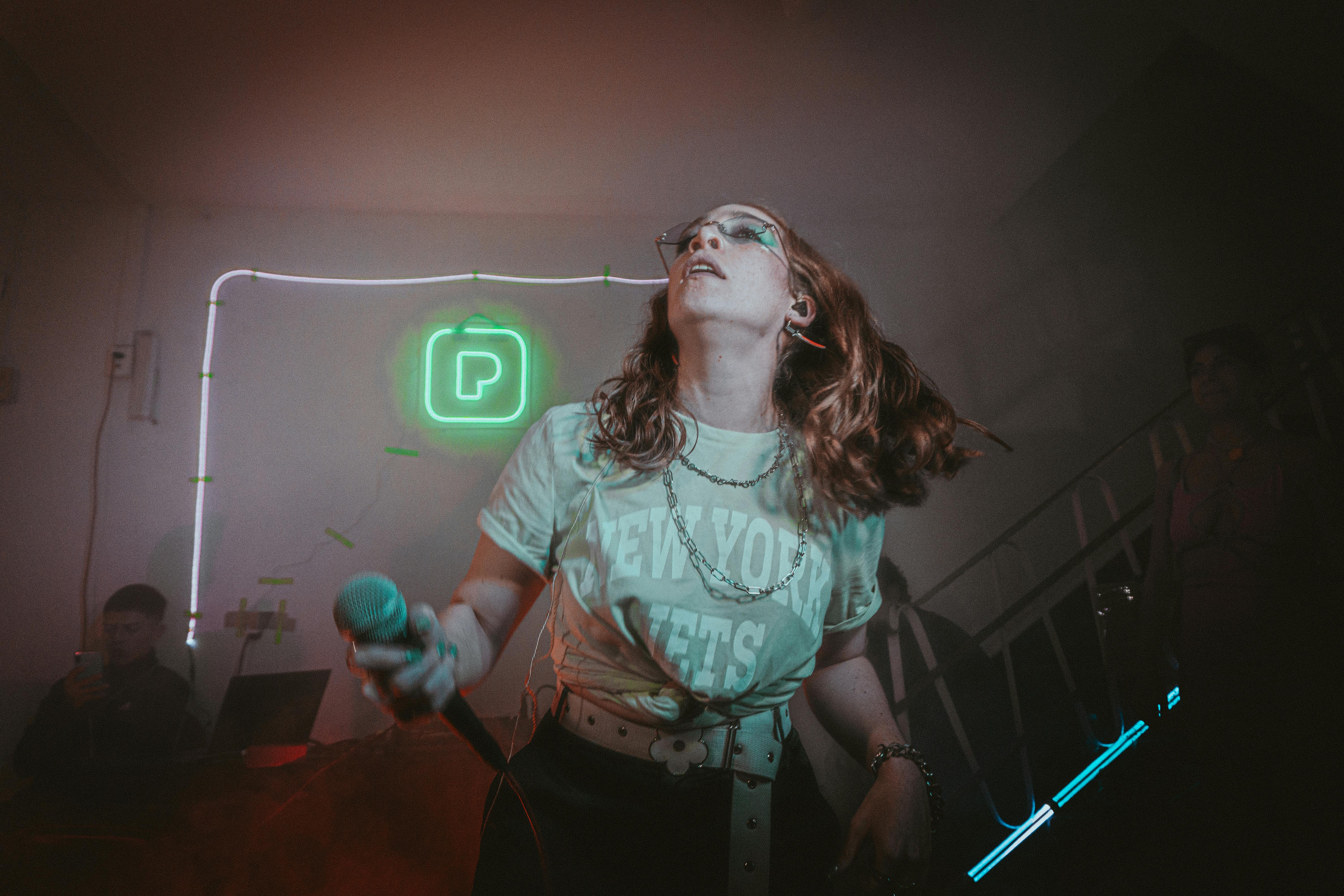 Photo of a Singer Performing on a Stage with Neon · Free Stock Photo