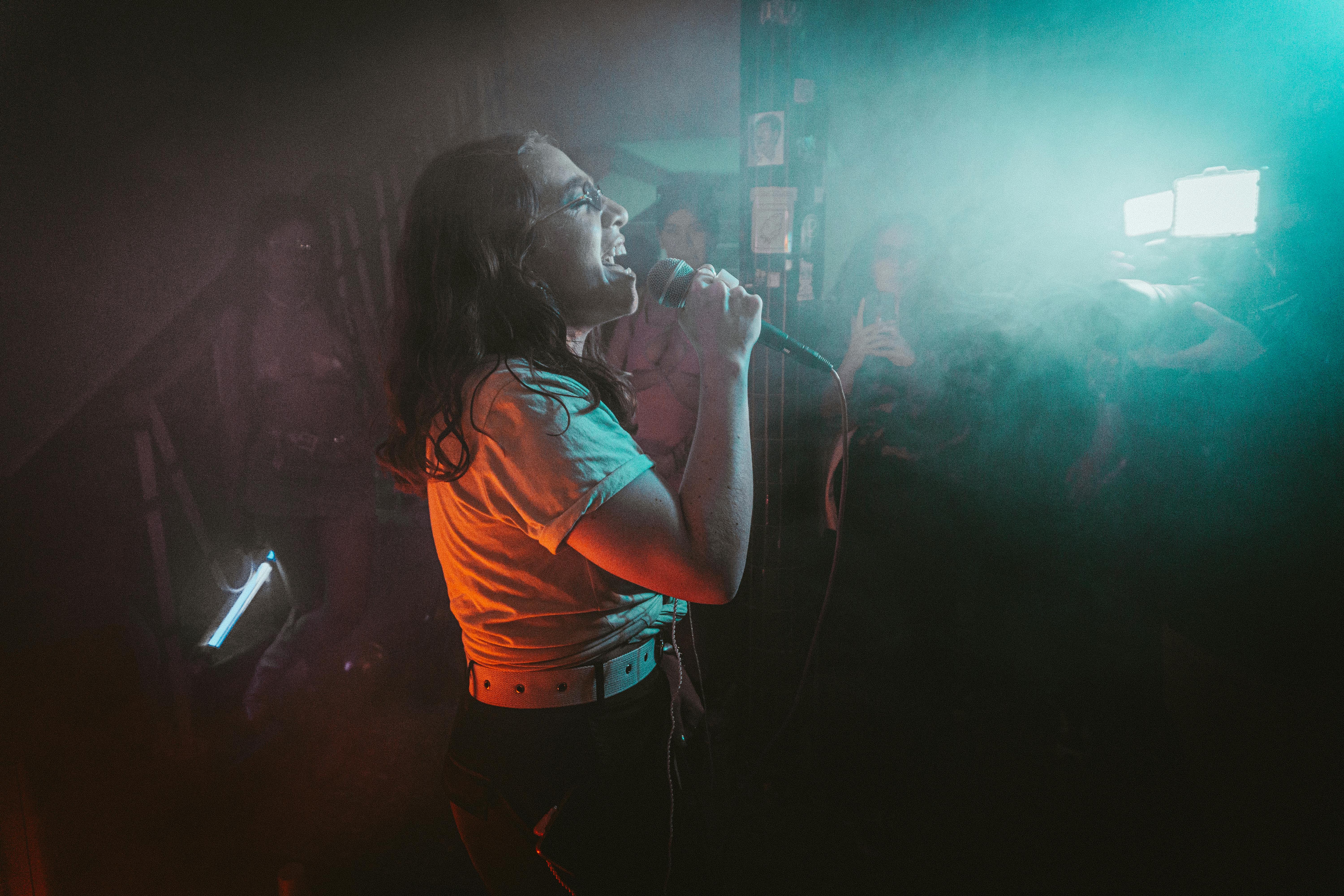 Singer in Red Dress Standing on Stage · Free Stock Photo
