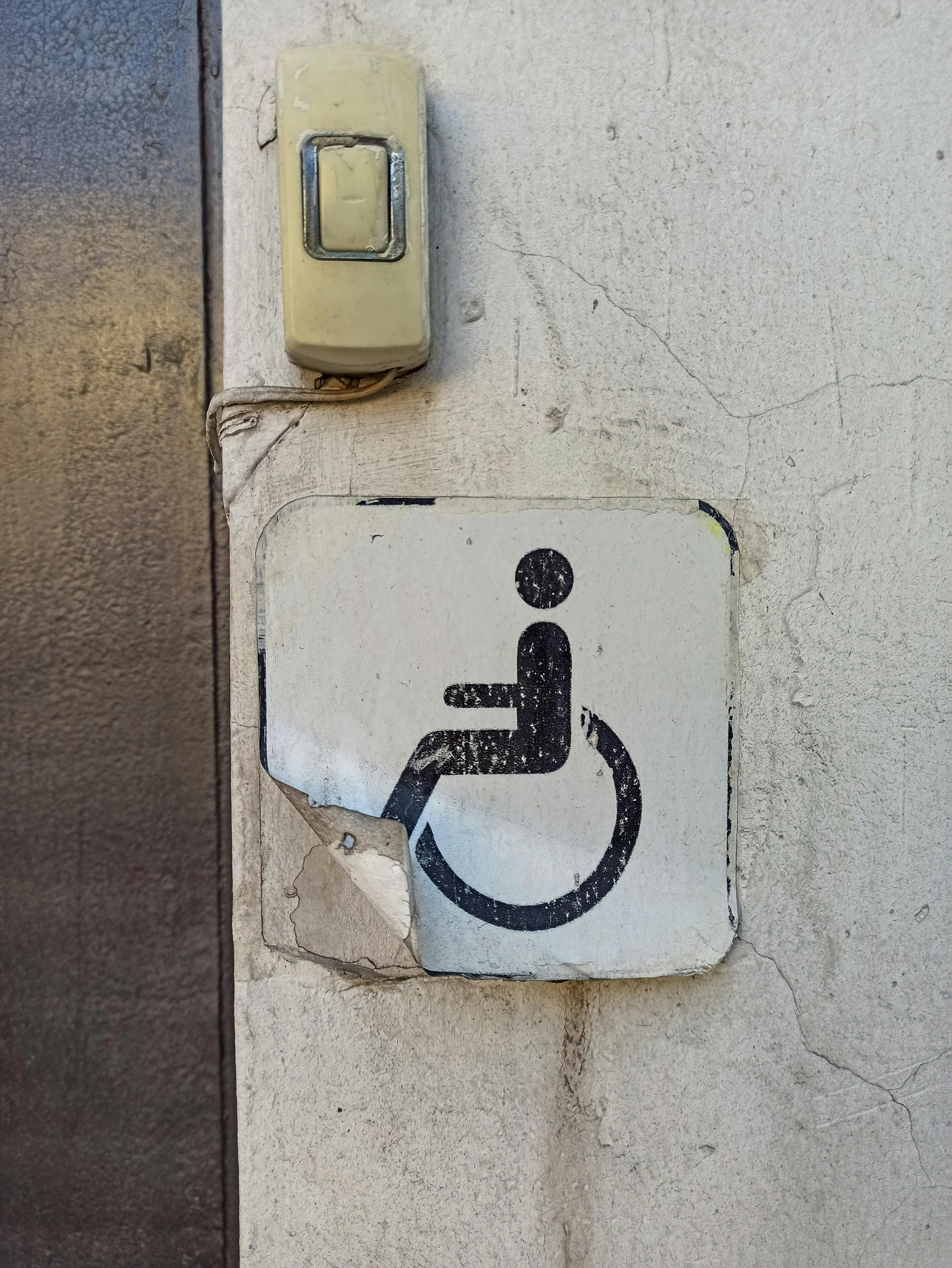 Old Handicapped Sign Peeling off Wall · Free Stock Photo