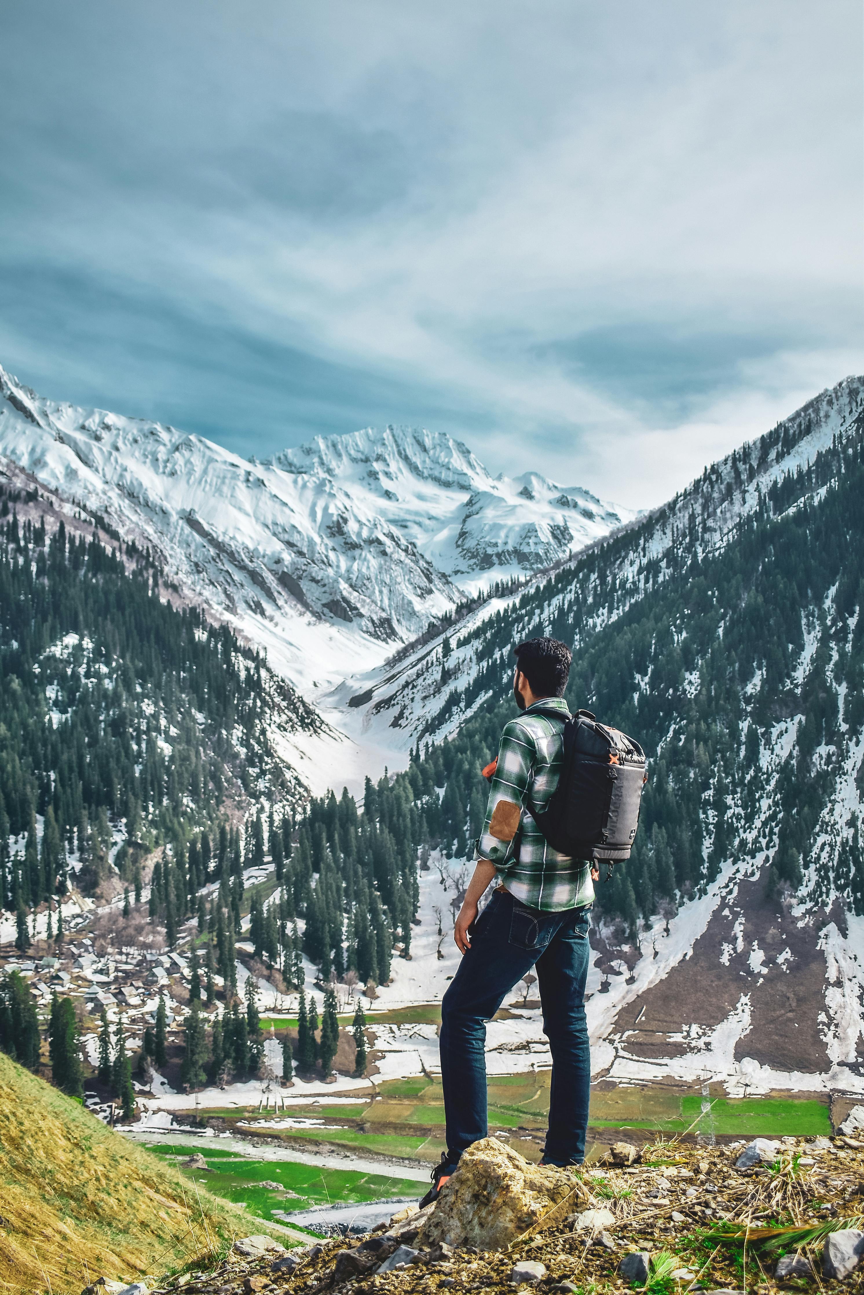 Man with a Backpack Looking at a Scenic Snowy Mountain Landscape · Free ...