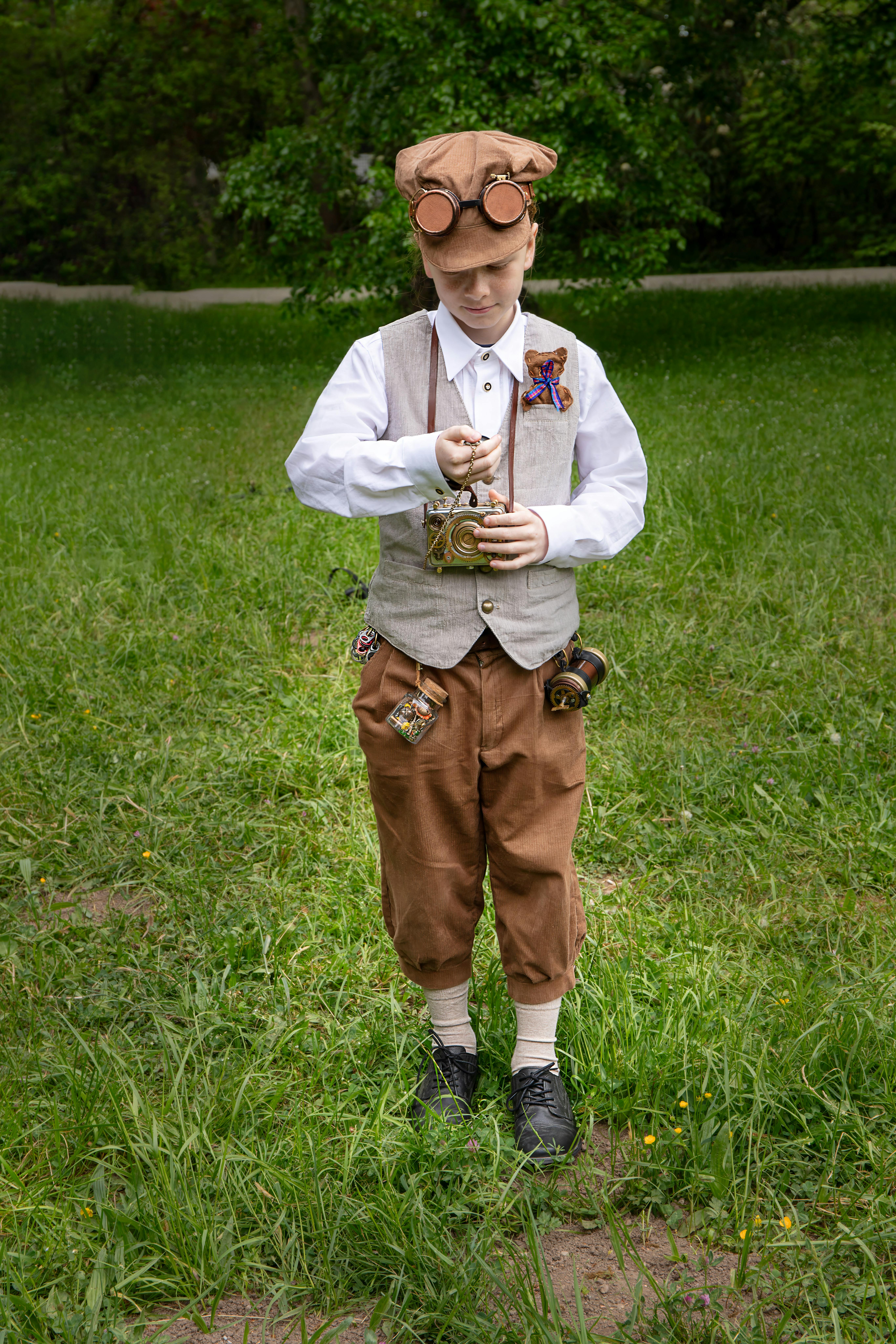 A Boy in a Steampunk Costume Standing on a Field · Free Stock Photo