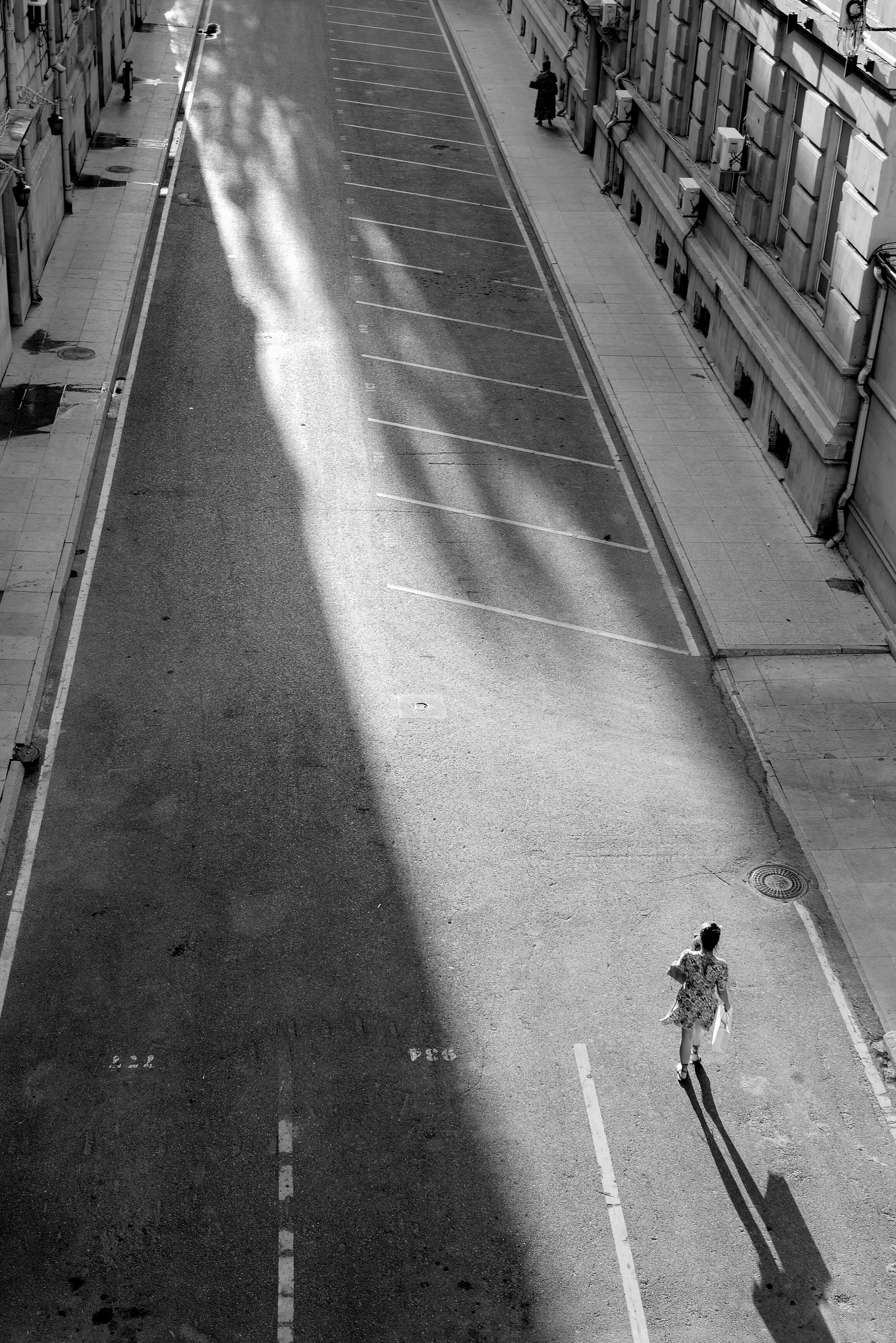 Grayscale Photo of Man Walking on Street Near Buildings · Free Stock Photo