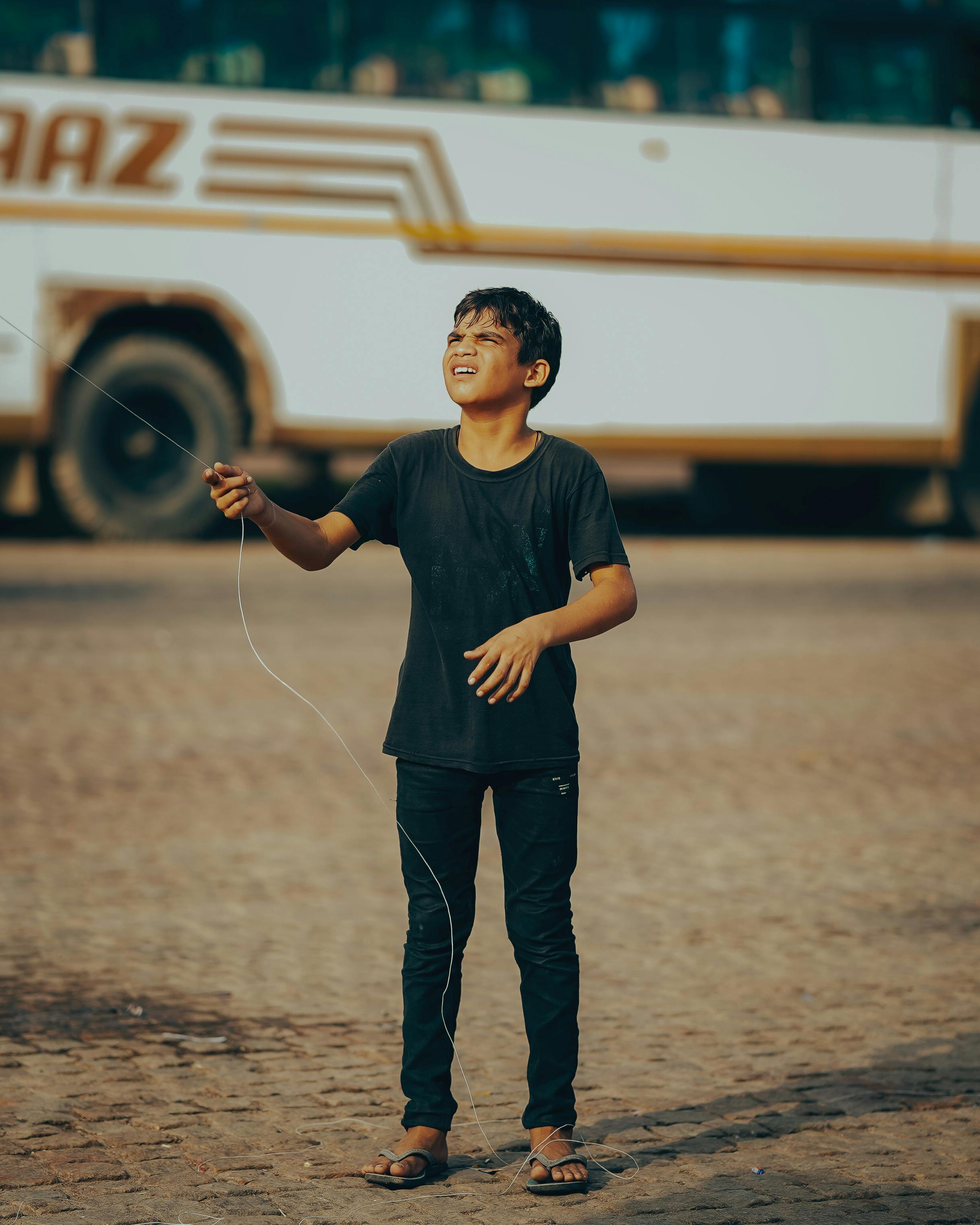 Boy Standing on Pavement and Holding String · Free Stock Photo