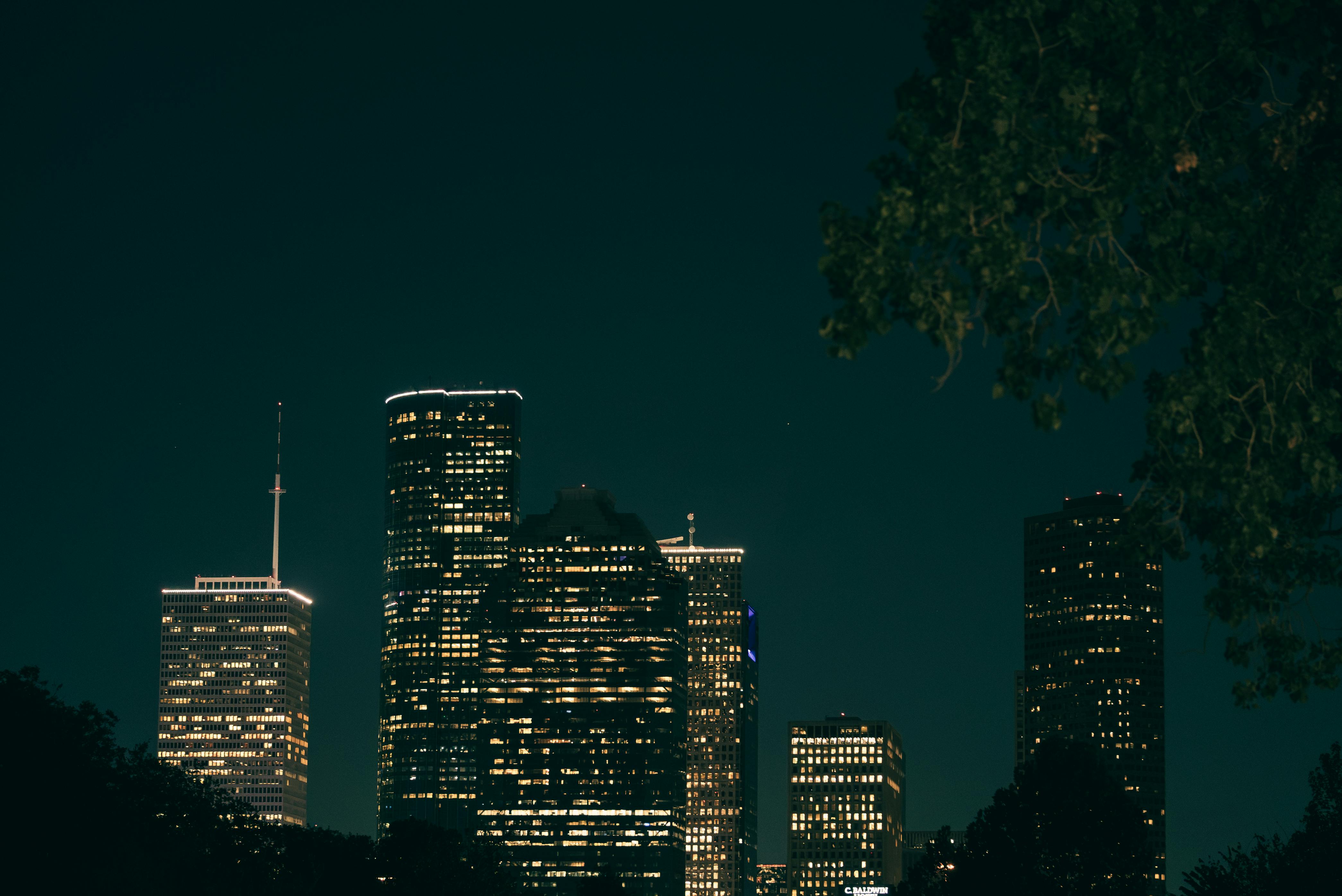 Illuminated Skyscrapers against Dark Night Sky · Free Stock Photo