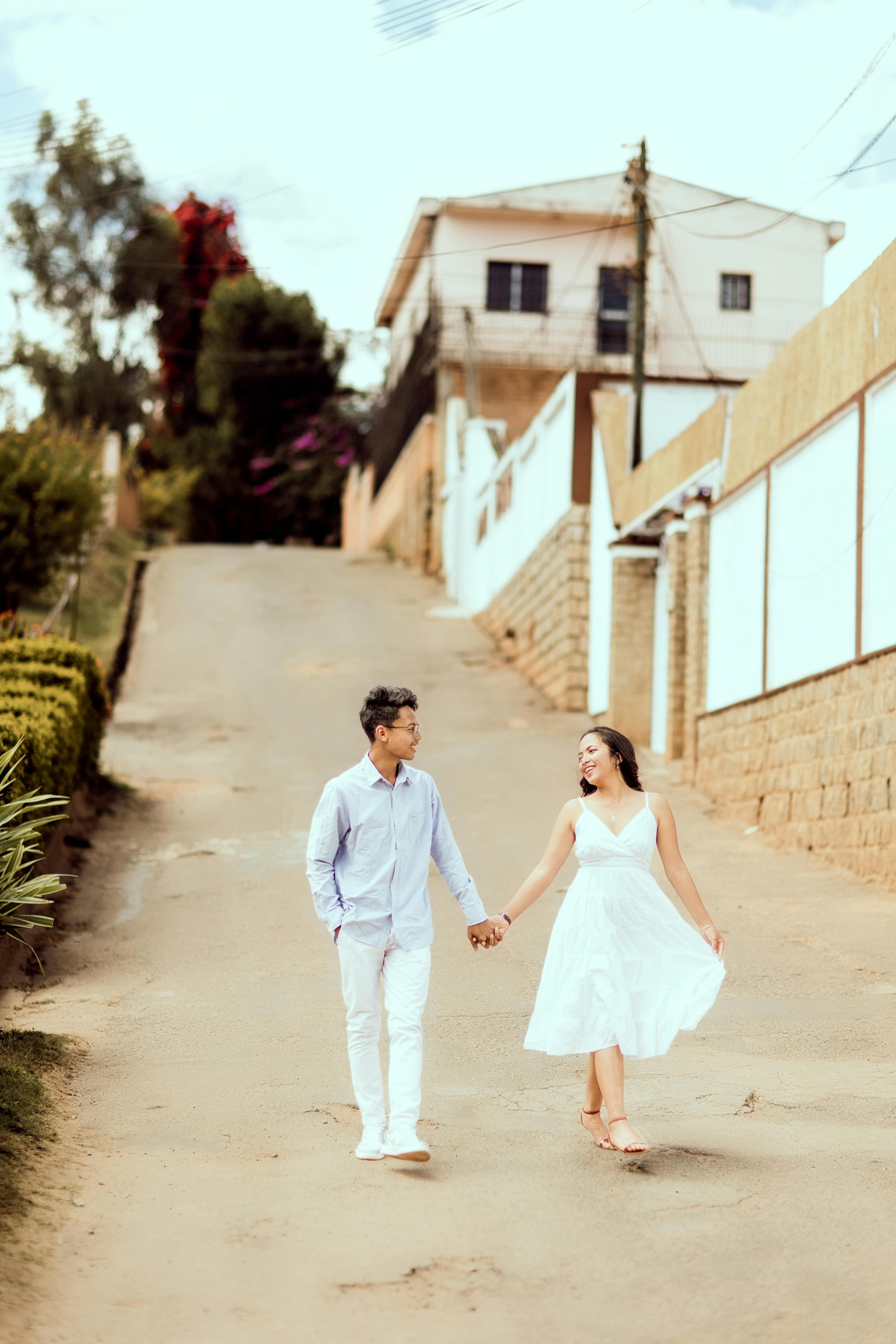 Smiling Couple in White Dress and Shirt Walking on Street in Town ...