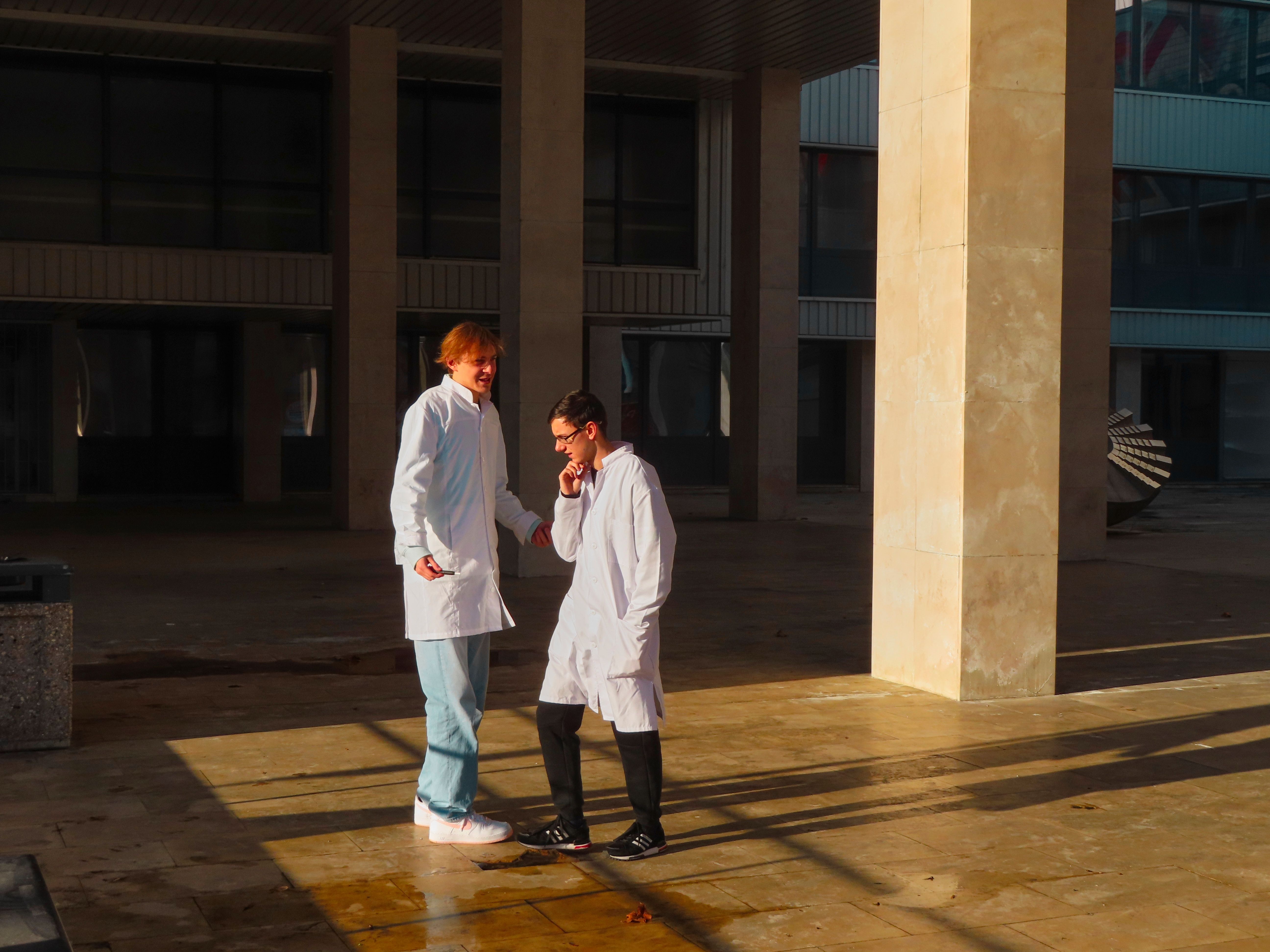 Men in White Medical Uniform Walking on Building Square · Free Stock Photo