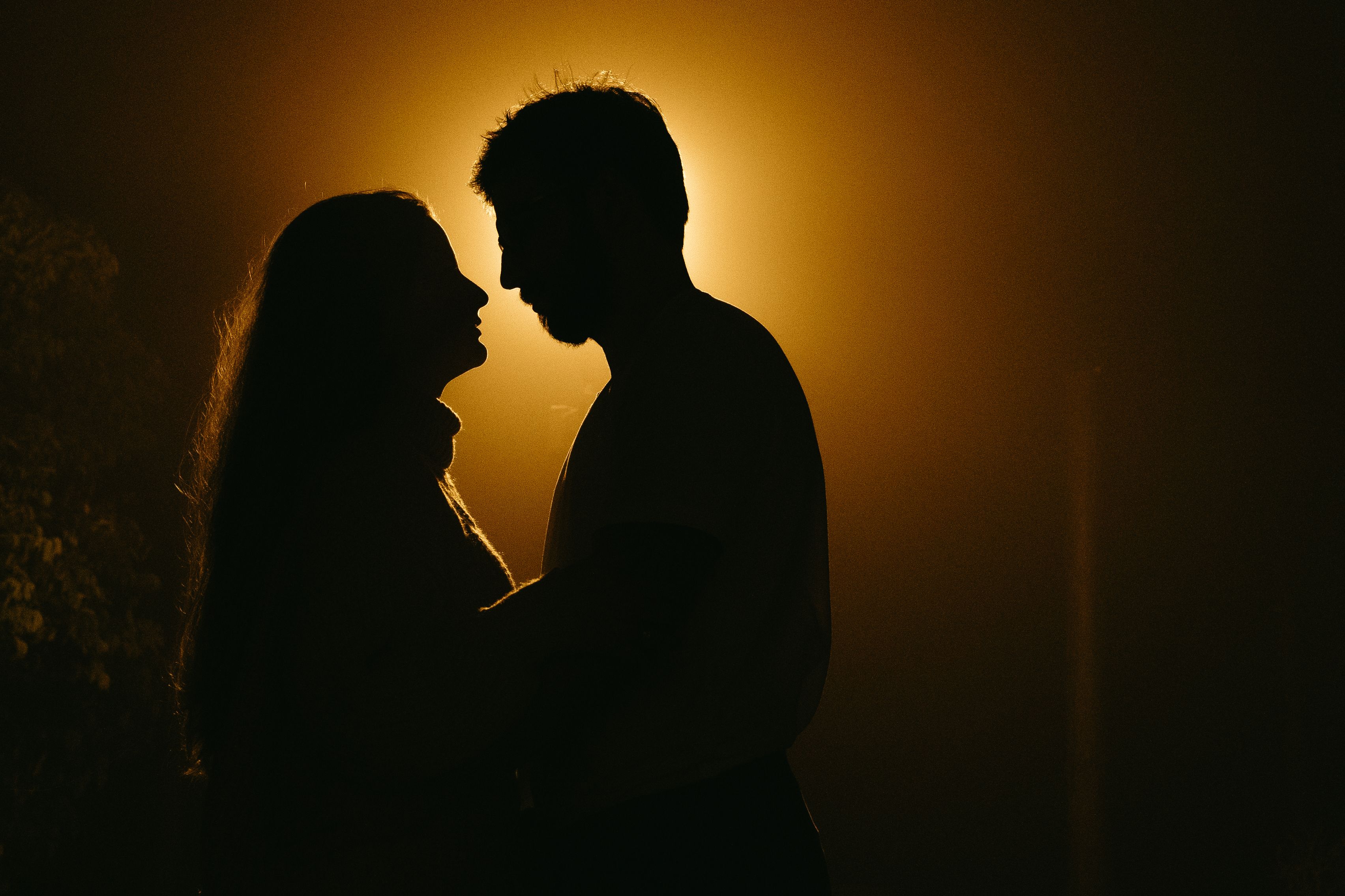 Illuminated Man and Woman Standing Face to Face in Darkness · Free ...