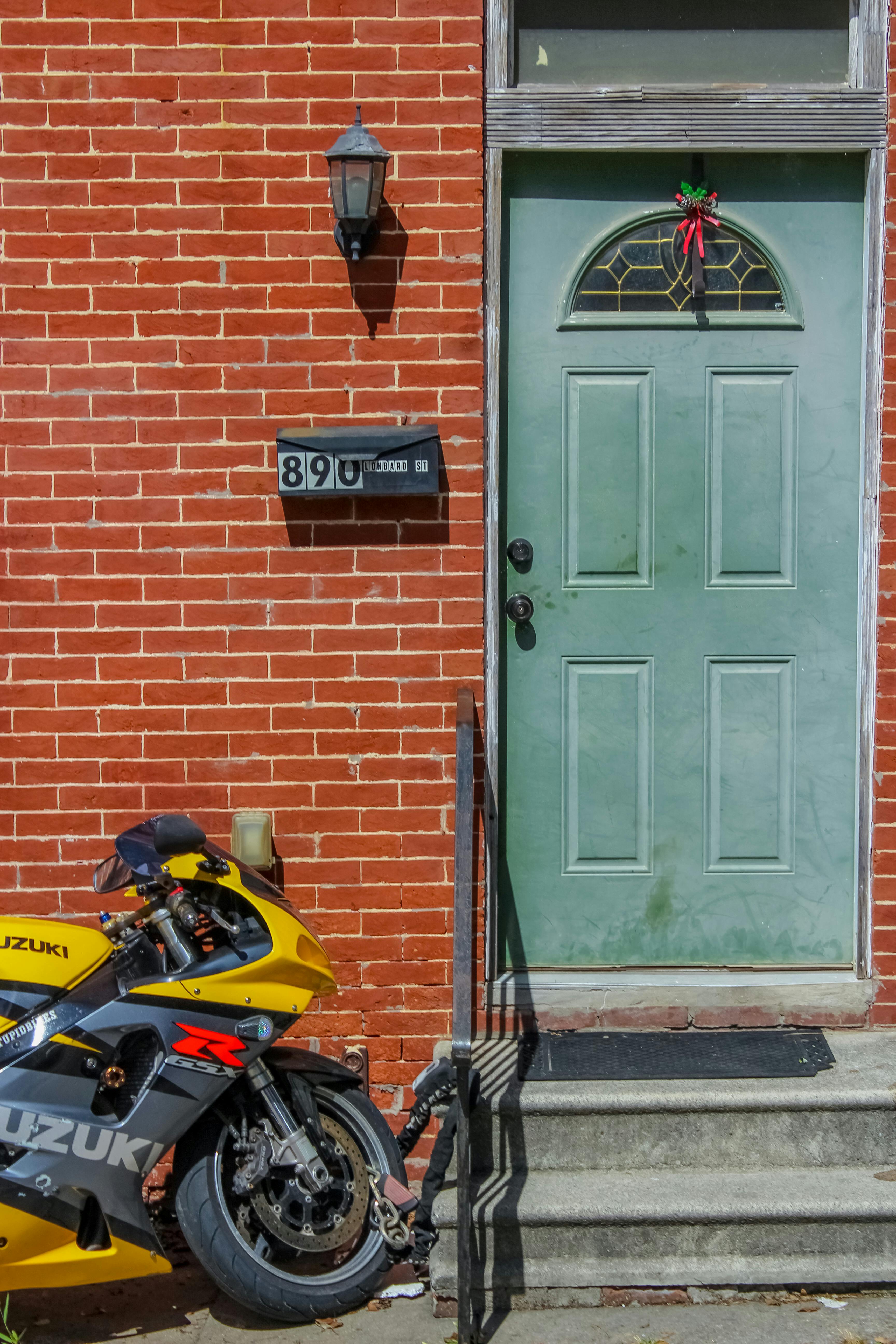 Yellow Suzuki Motorcycle Parked at a House Porch · Free Stock Photo