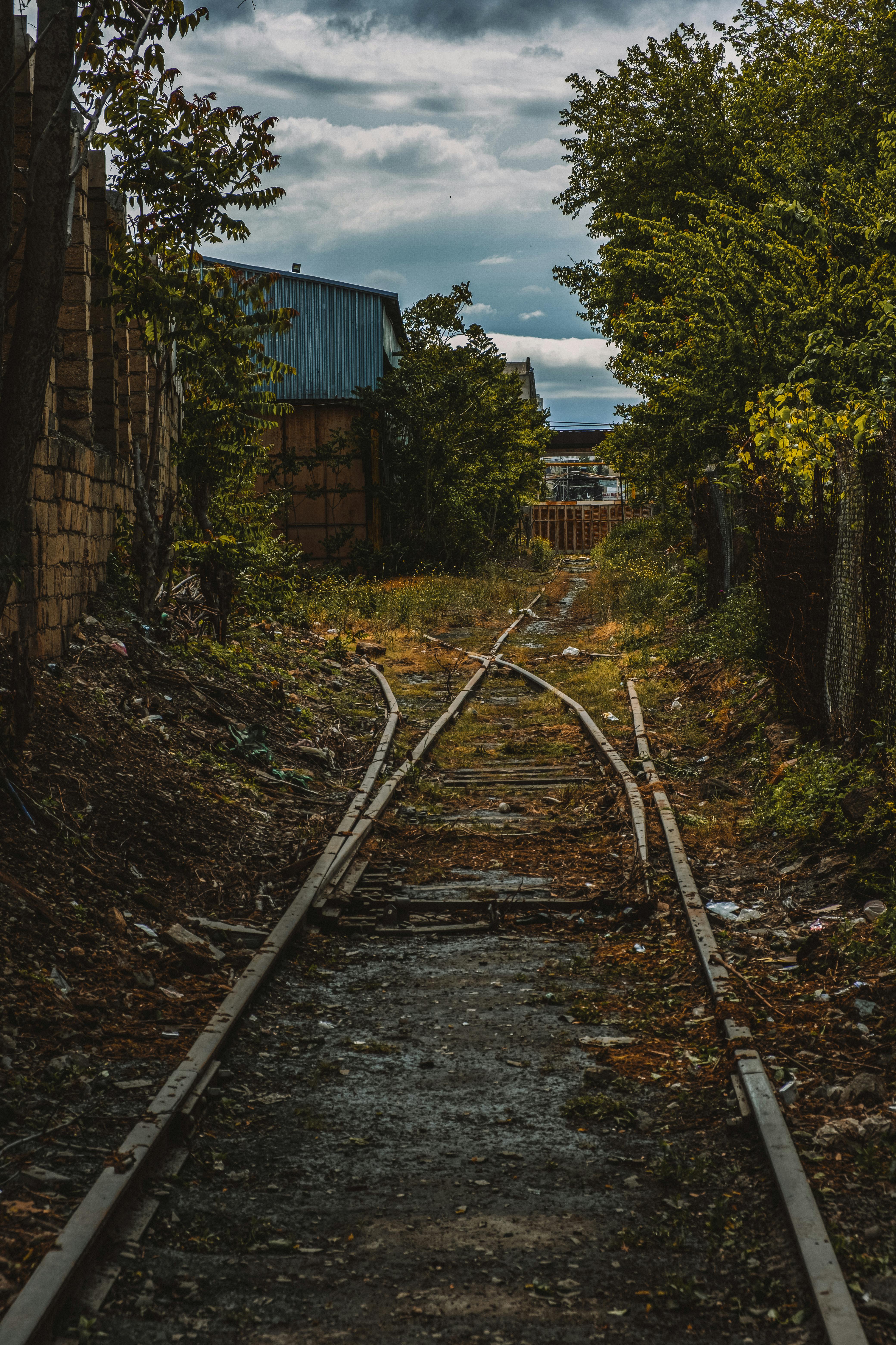 Landscape with a Hut and Weathered Railway Track · Free Stock Photo