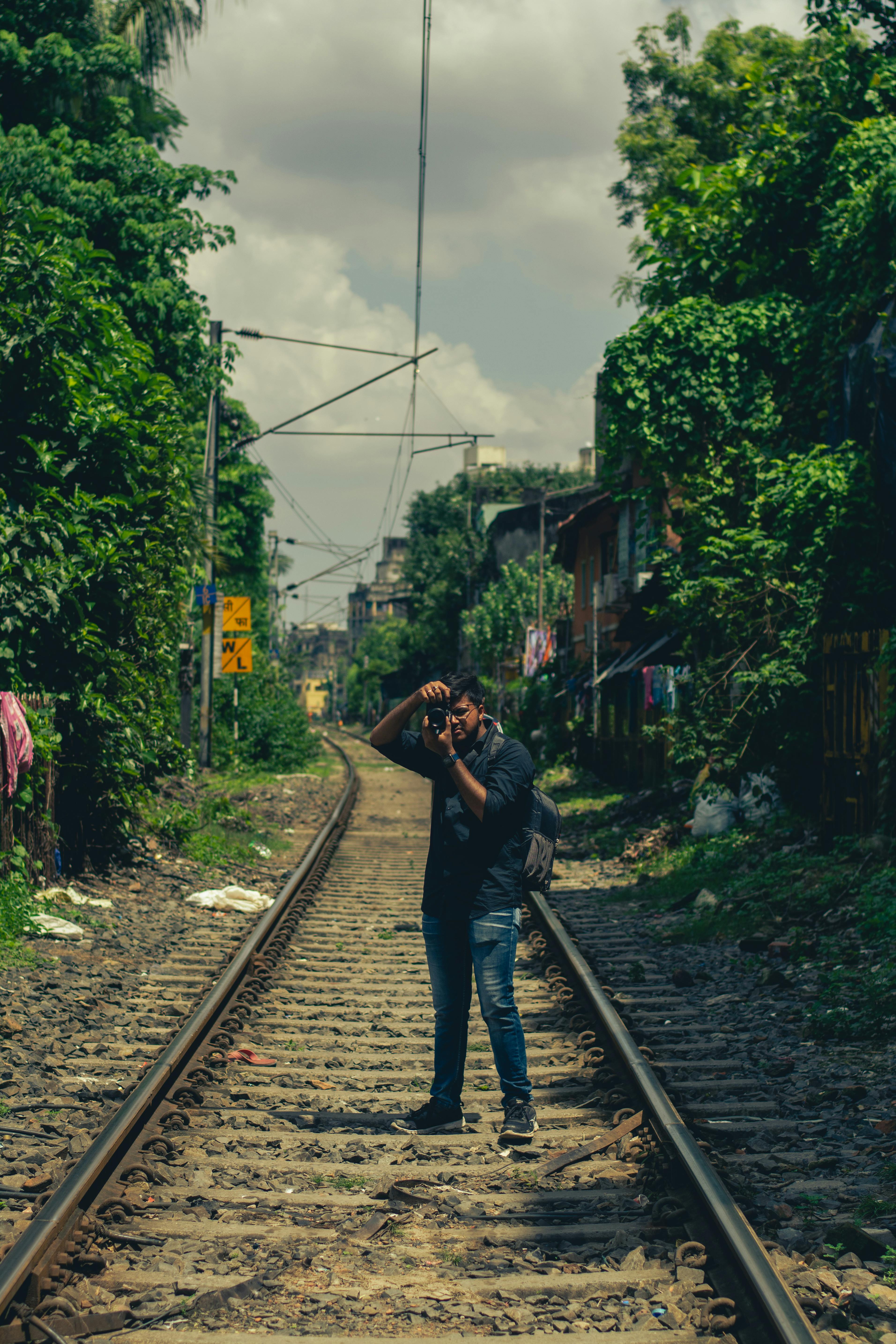 Man Taking Pictures on Railway in Town · Free Stock Photo