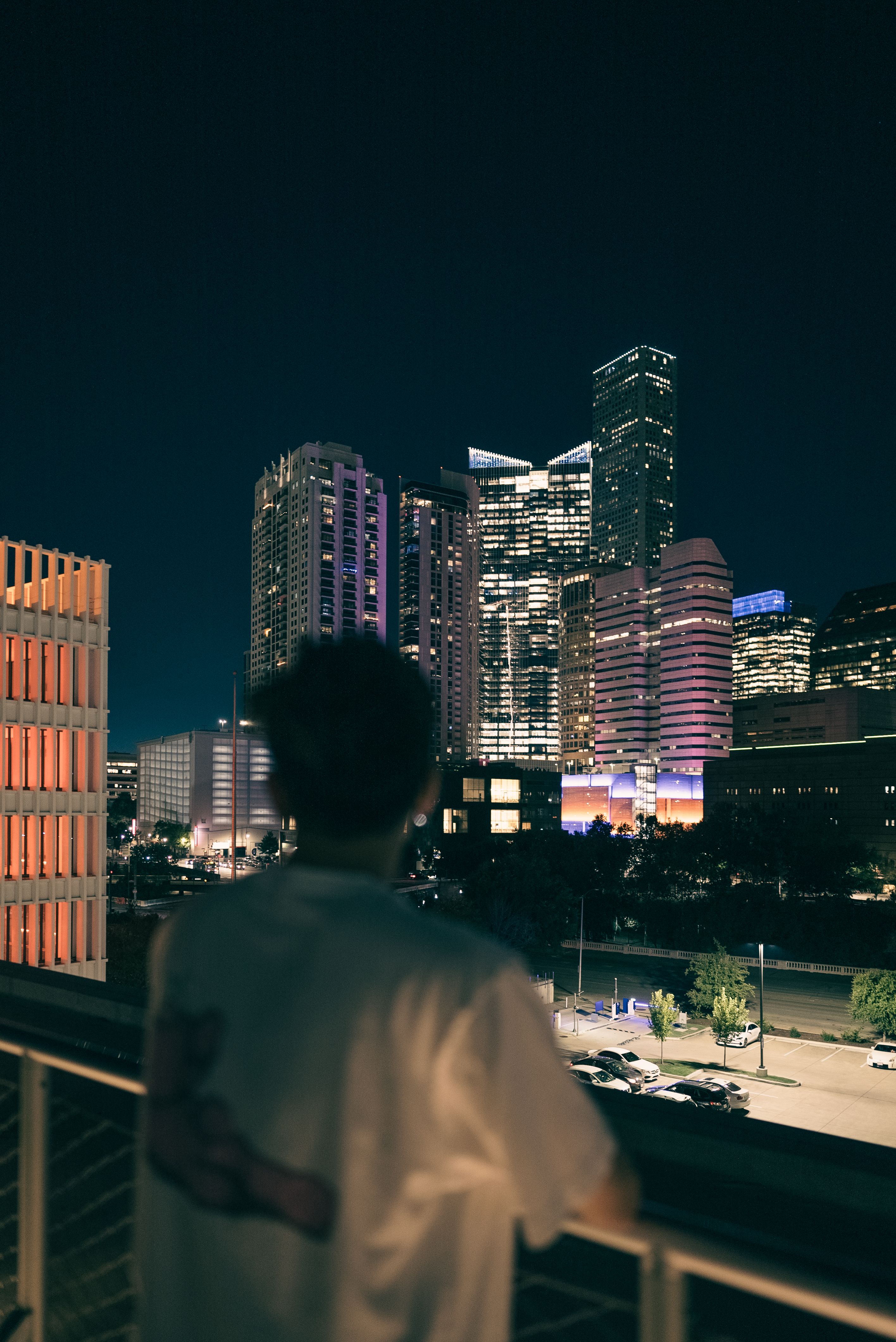 City Buildings behind Man at Night · Free Stock Photo