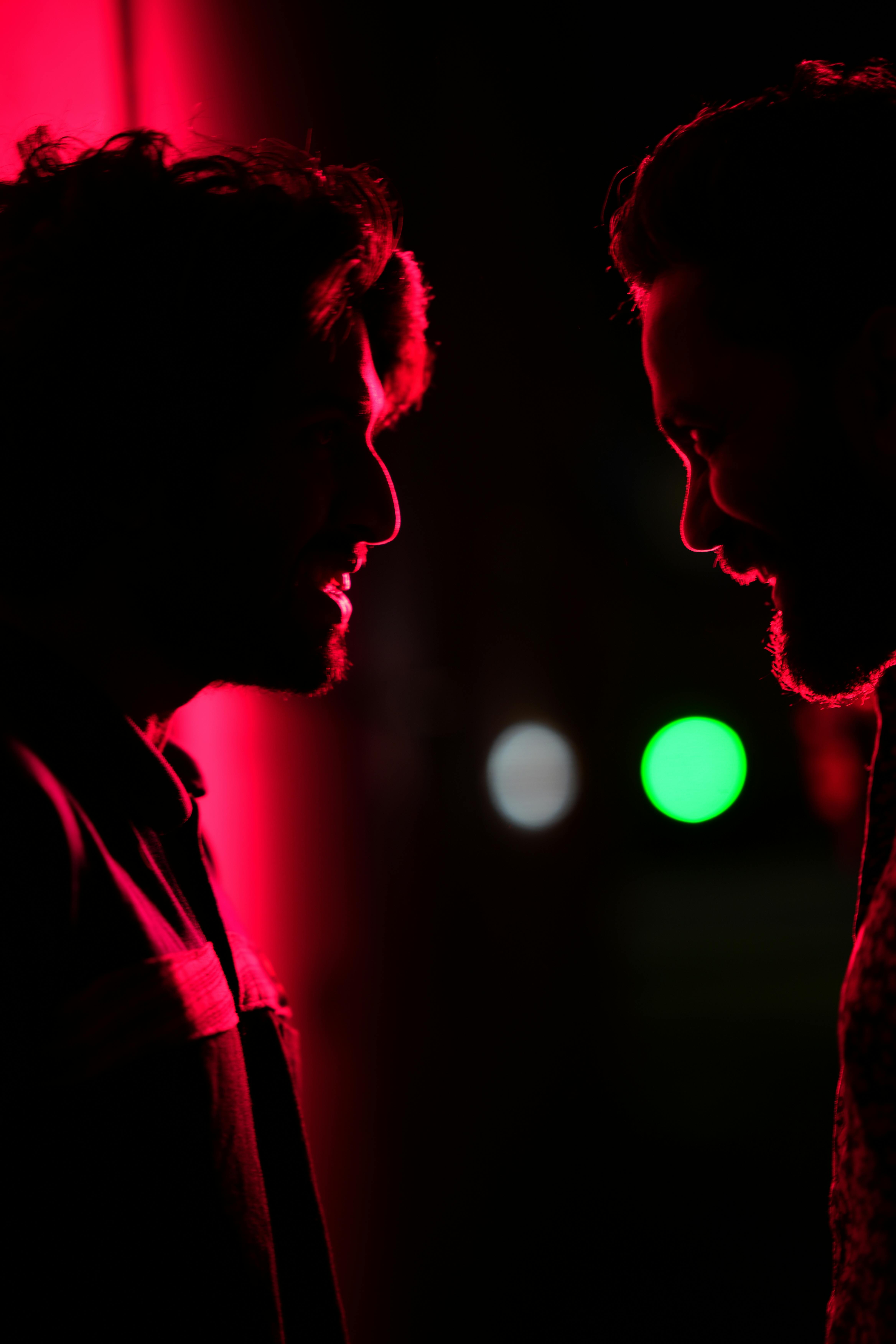 Silhouettes of Two Men Illuminated by Red Light · Free Stock Photo