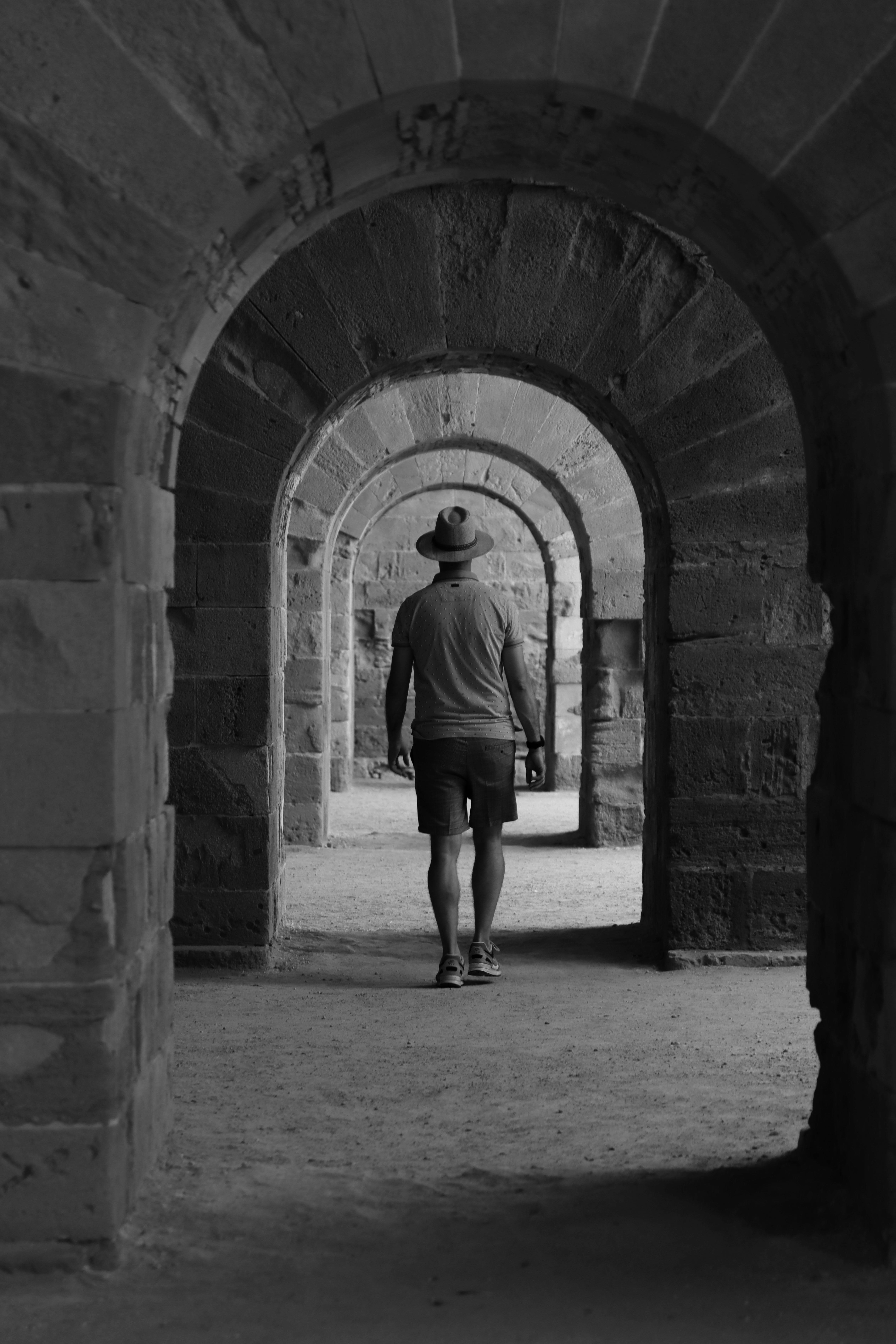 Man Kneeling Among the Archways · Free Stock Photo