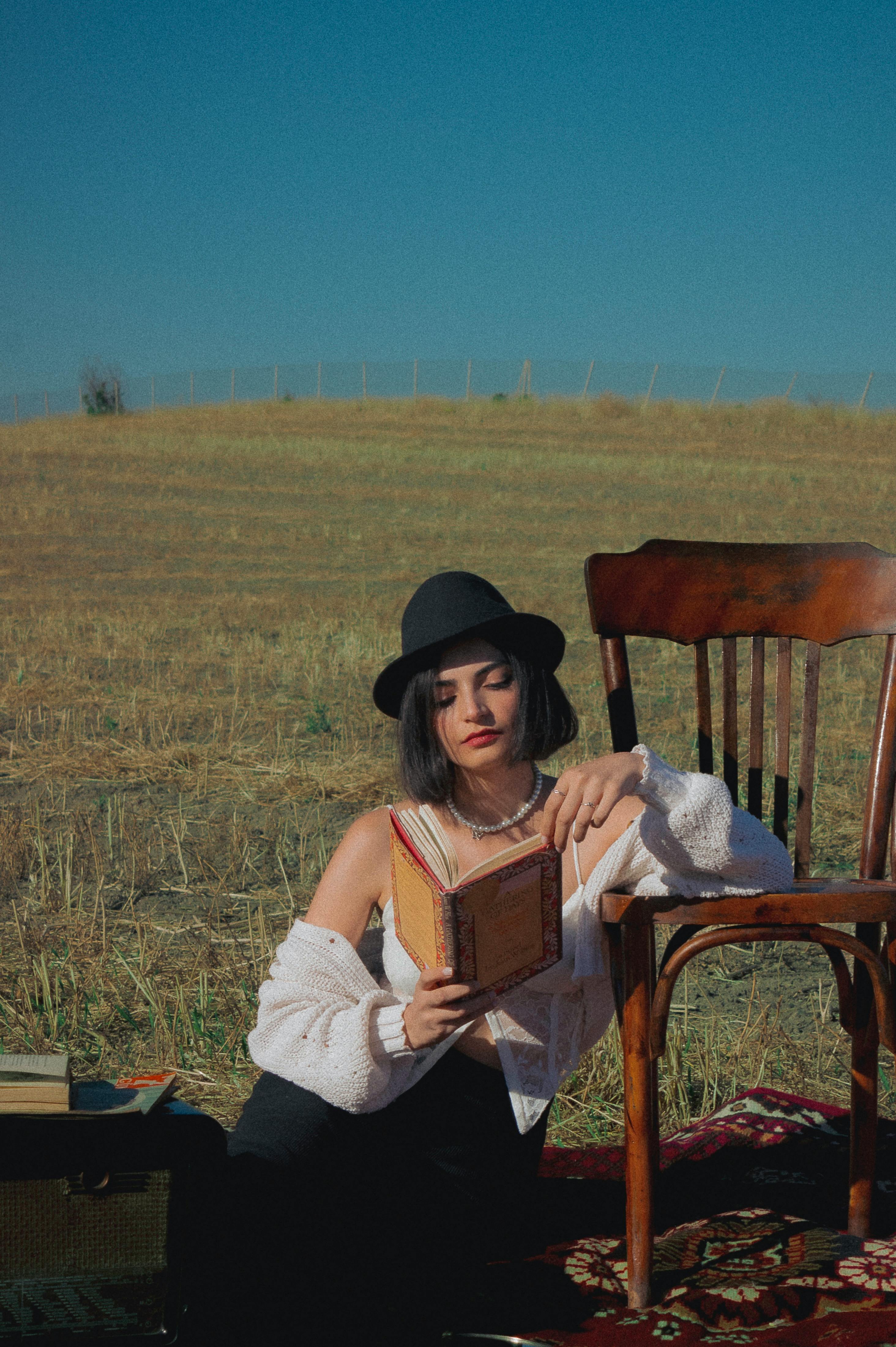 Retro Style Model with Book in Field · Free Stock Photo