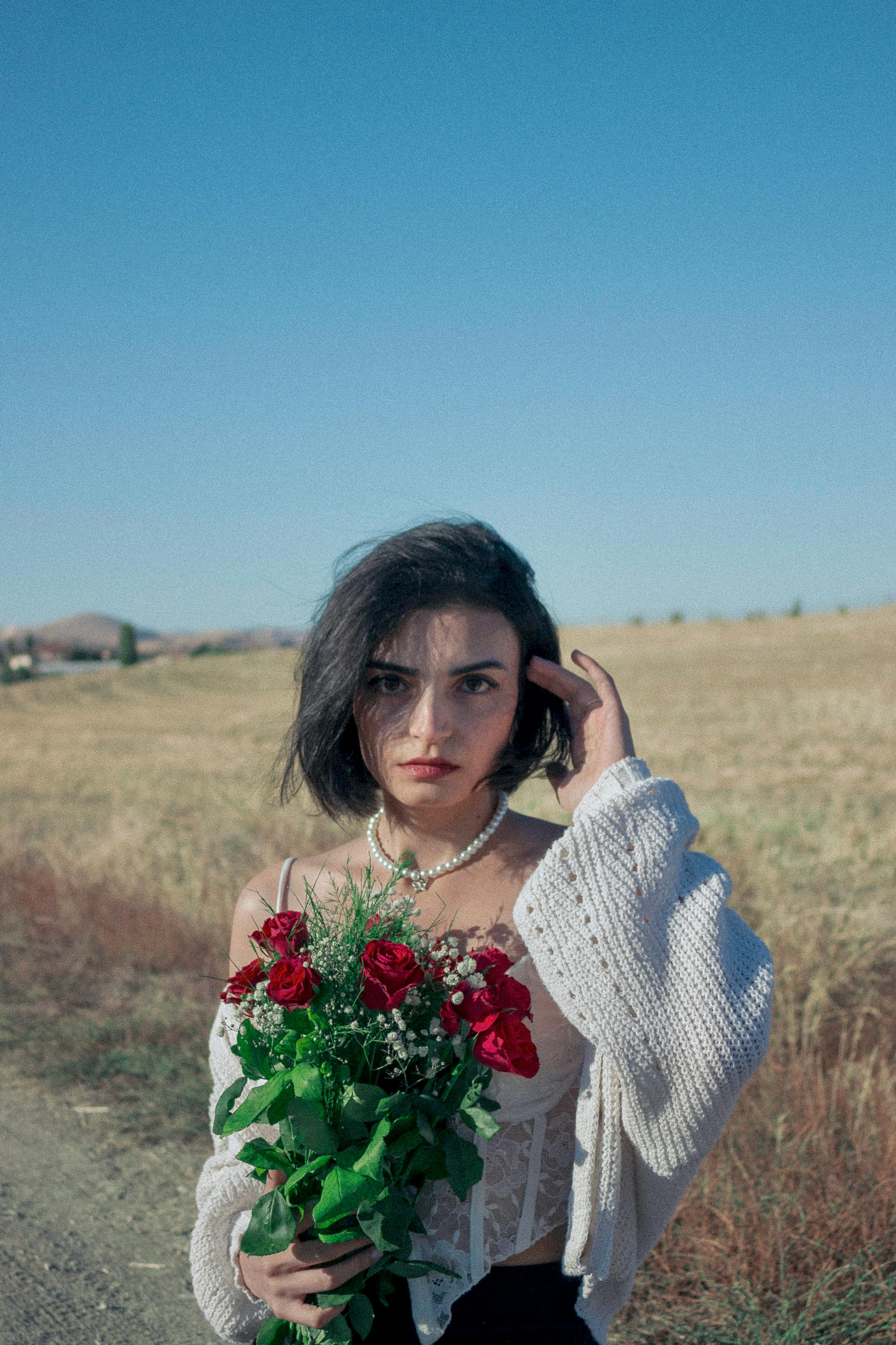 Brunette with Red Roses in Countryside · Free Stock Photo