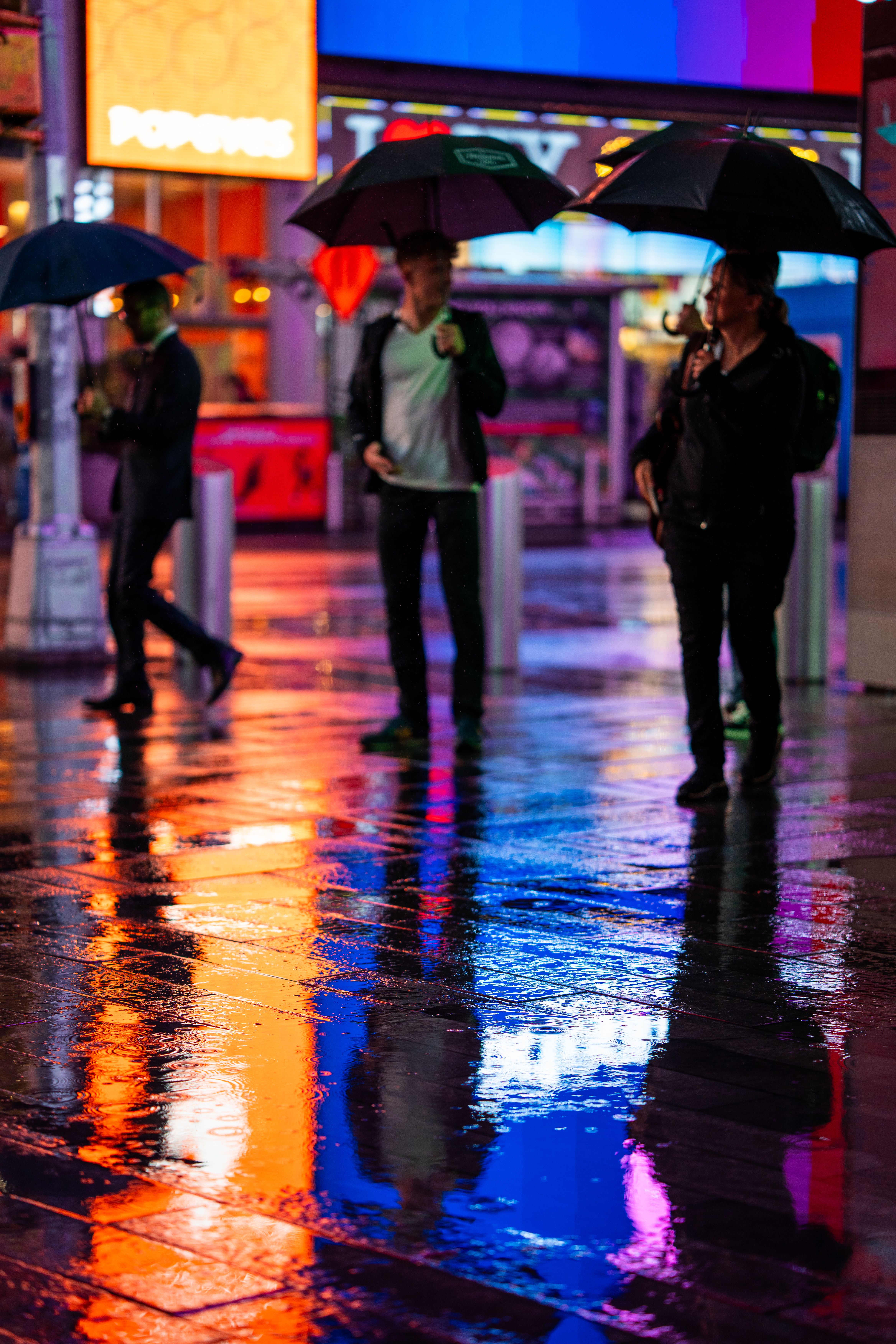 People with Umbrellas on the Rain-Drenched Pavement · Free Stock Photo