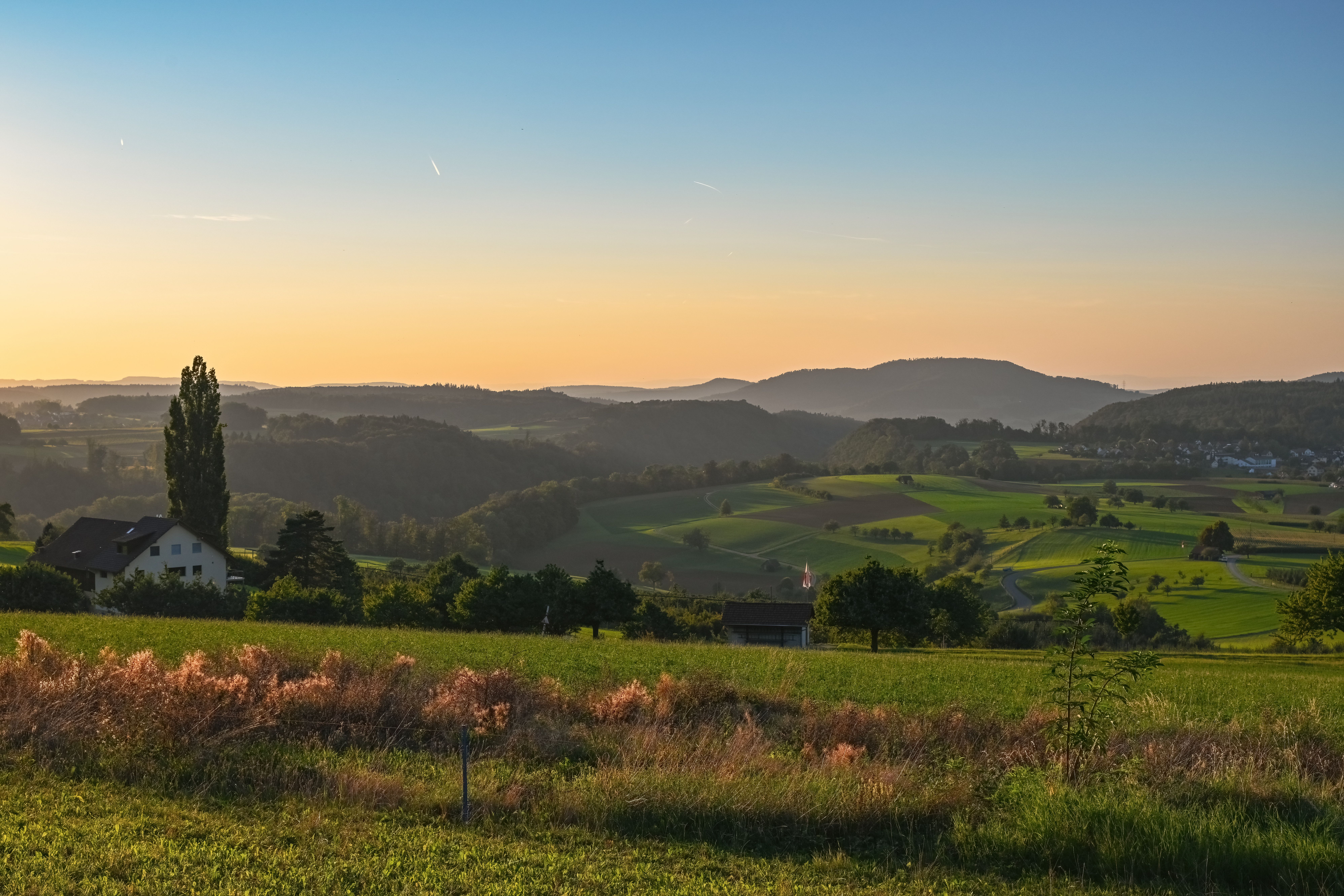 Green Fields on Hills in Countryside at Sunset · Free Stock Photo