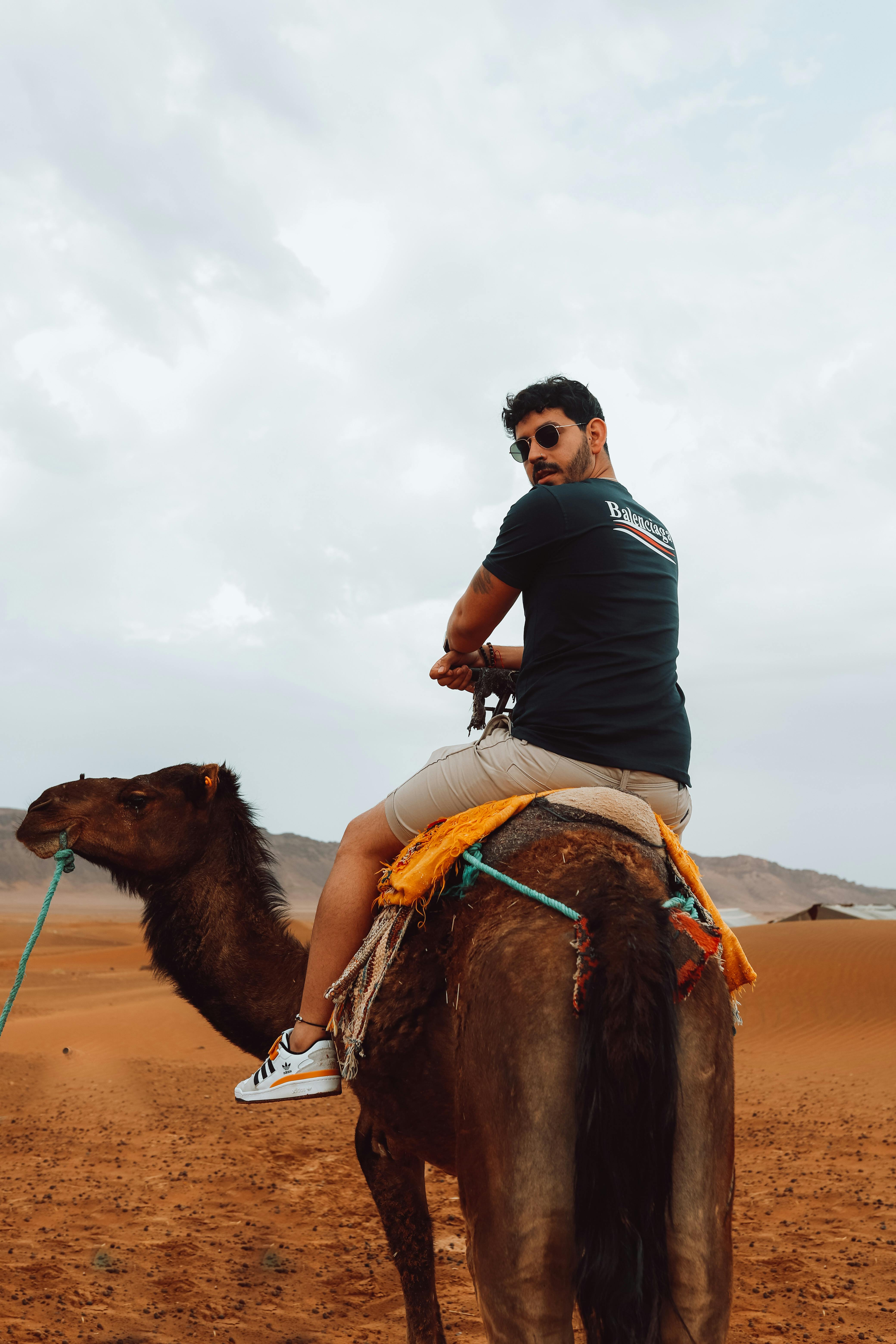 Human Riding Camel on Dessert Under White Sky during Daytime · Free ...