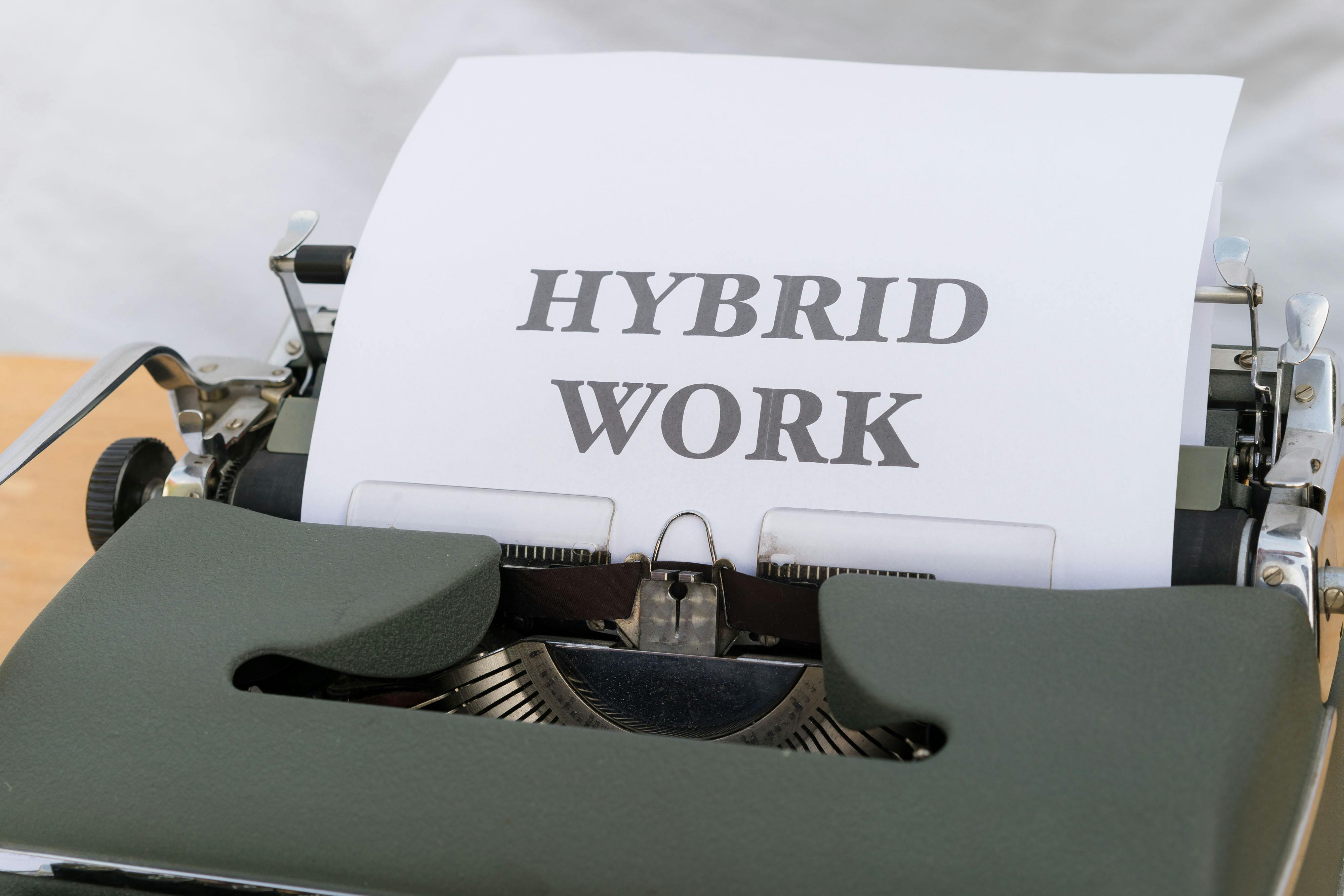 A typewriter with the words hybrid work on it · Free Stock Photo