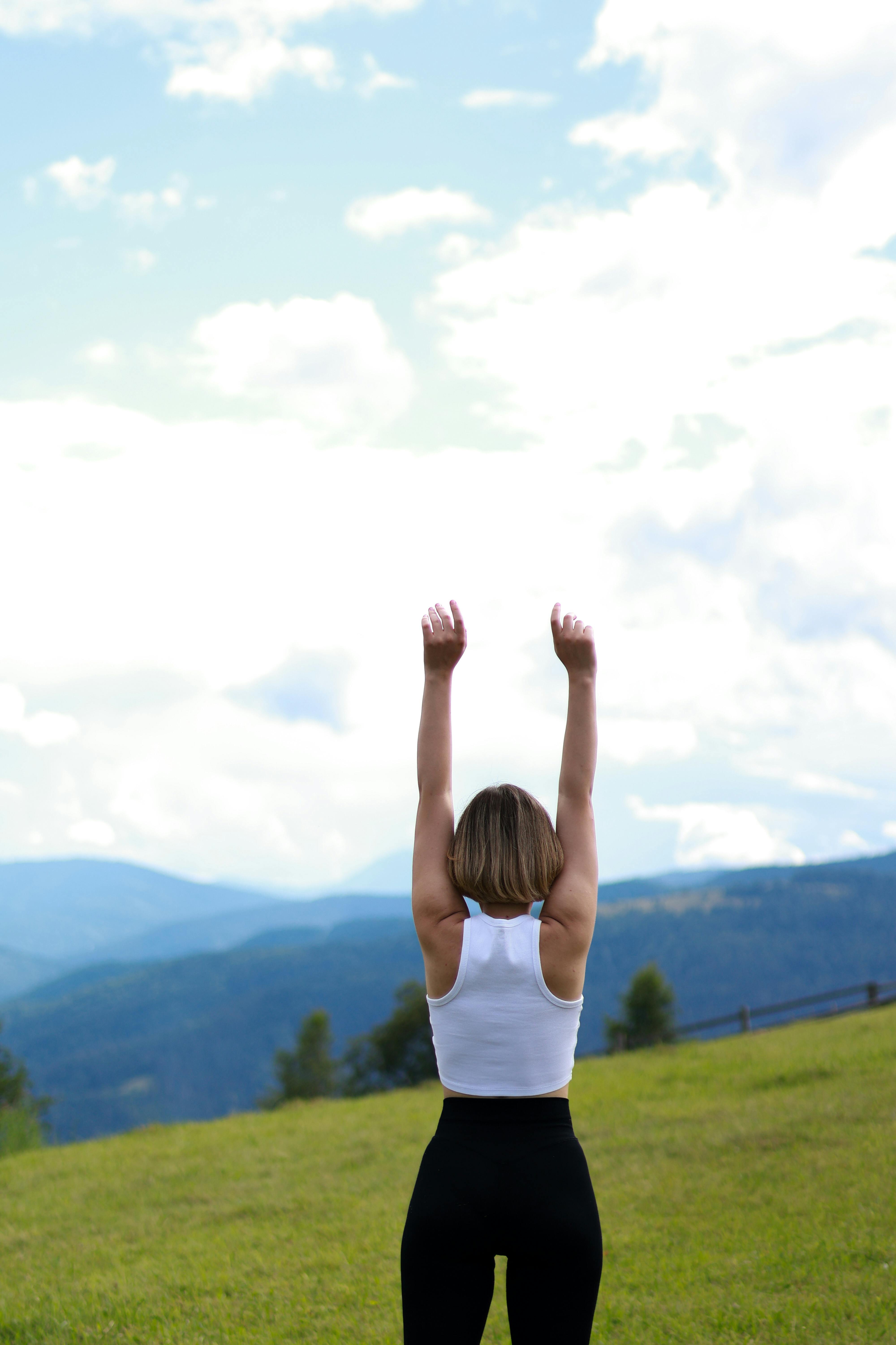 Back View of a Woman Standing with Arms Raised in Mountains · Free ...
