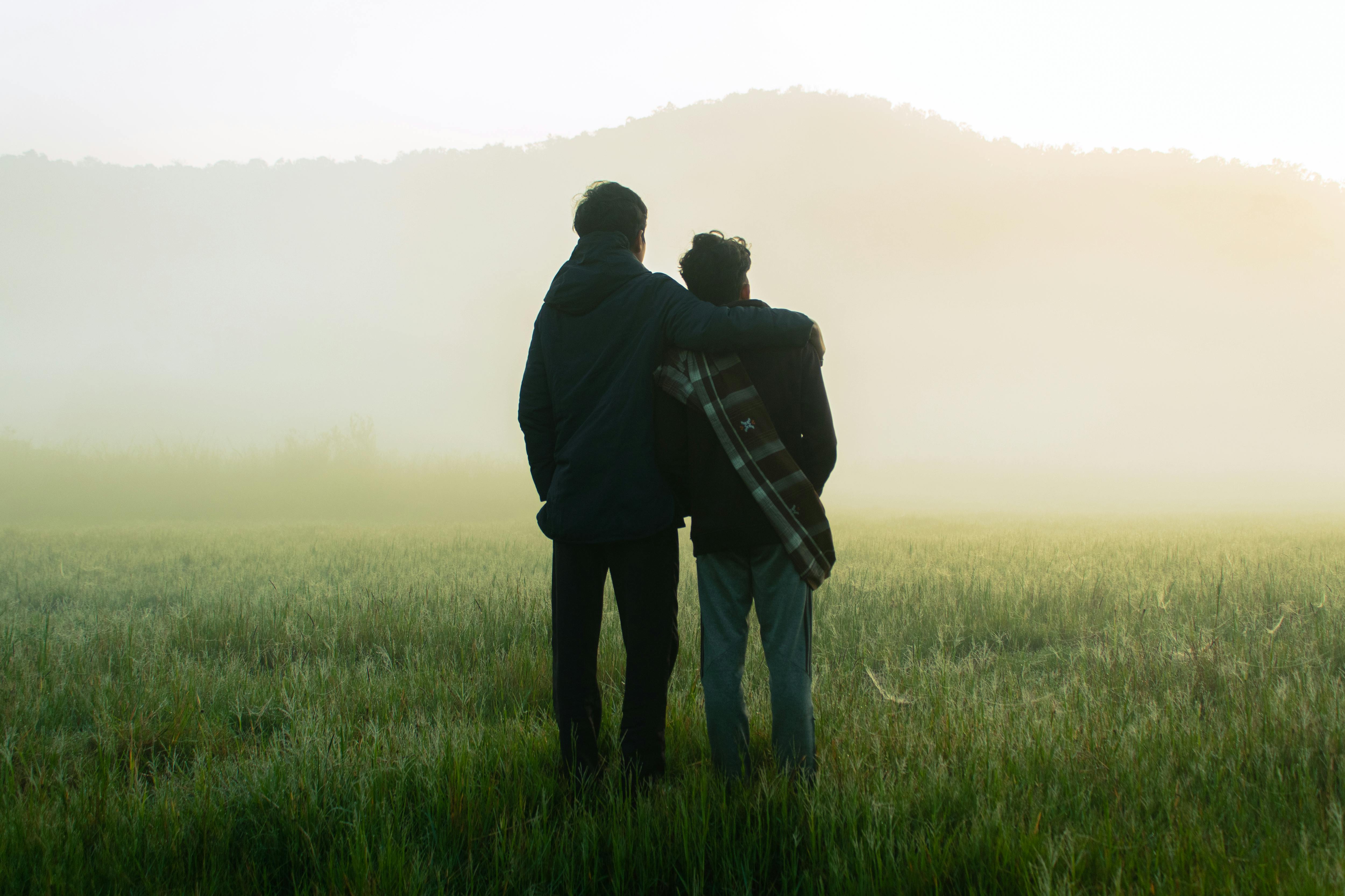 Two People Embracing in a Foggy Hayfield · Free Stock Photo