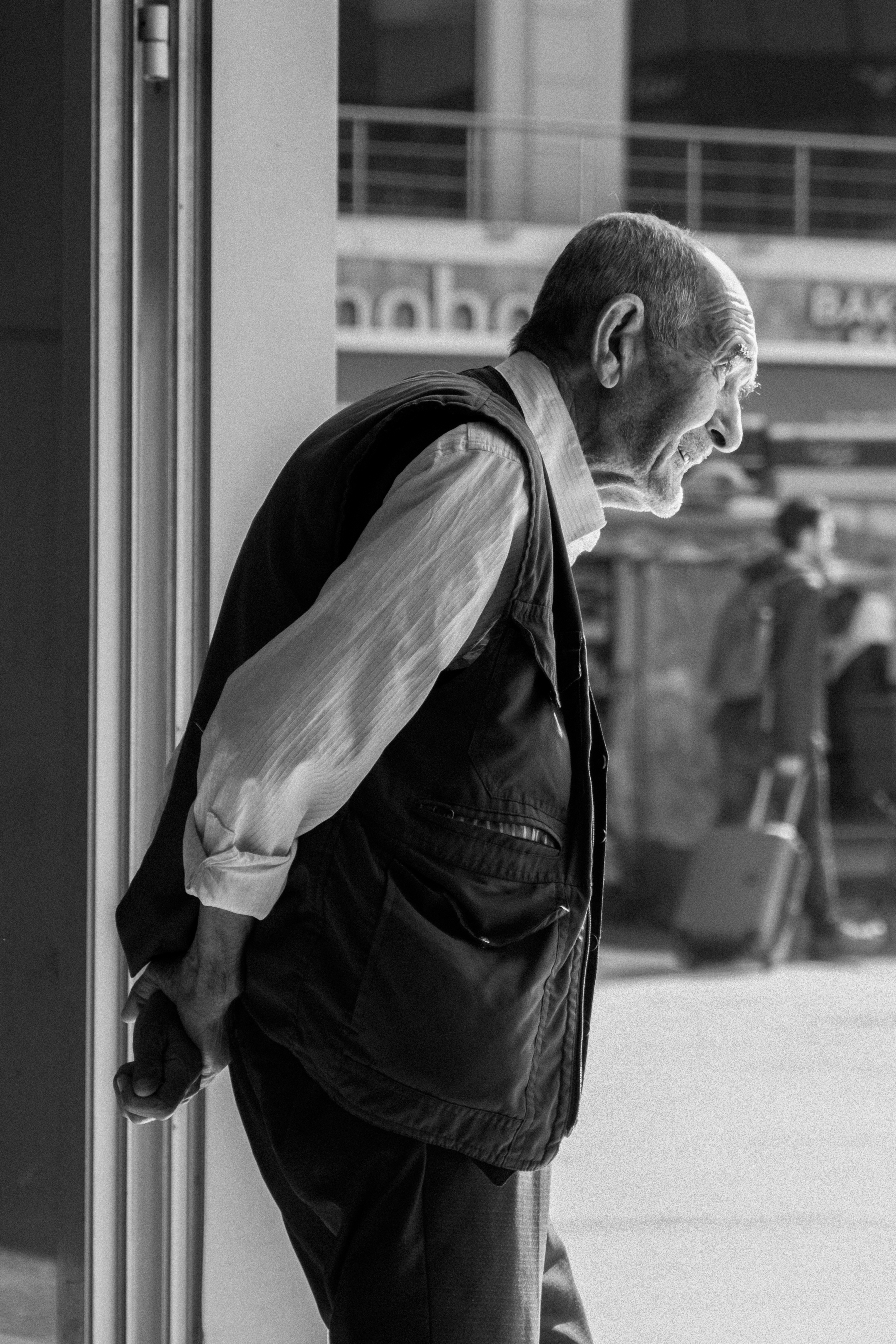 Photo of an Elderly Man Standing behind Old Door · Free Stock Photo