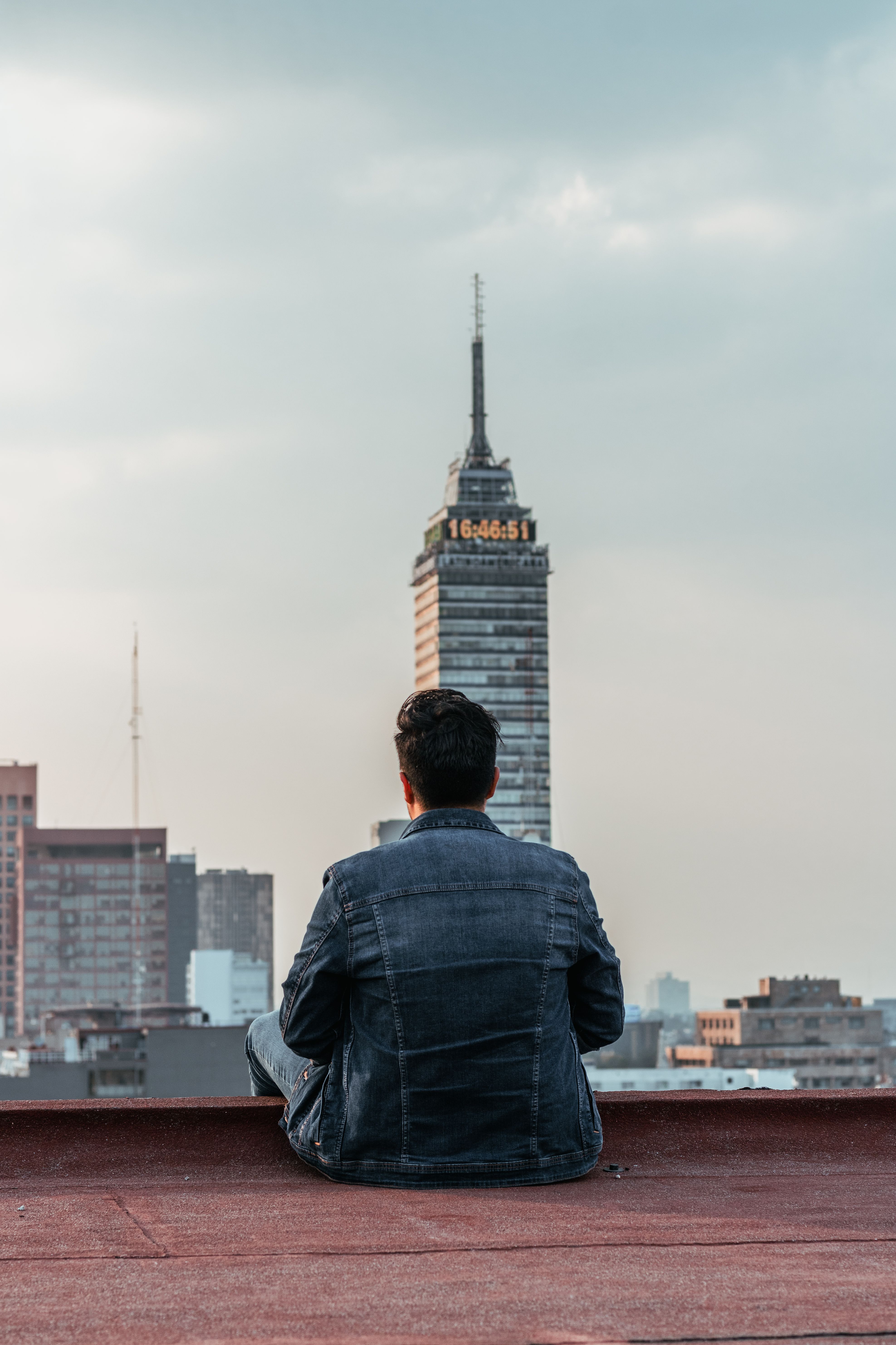 Man Sitting on Roof with Torre Latinoamericana behind in Mexico City ...