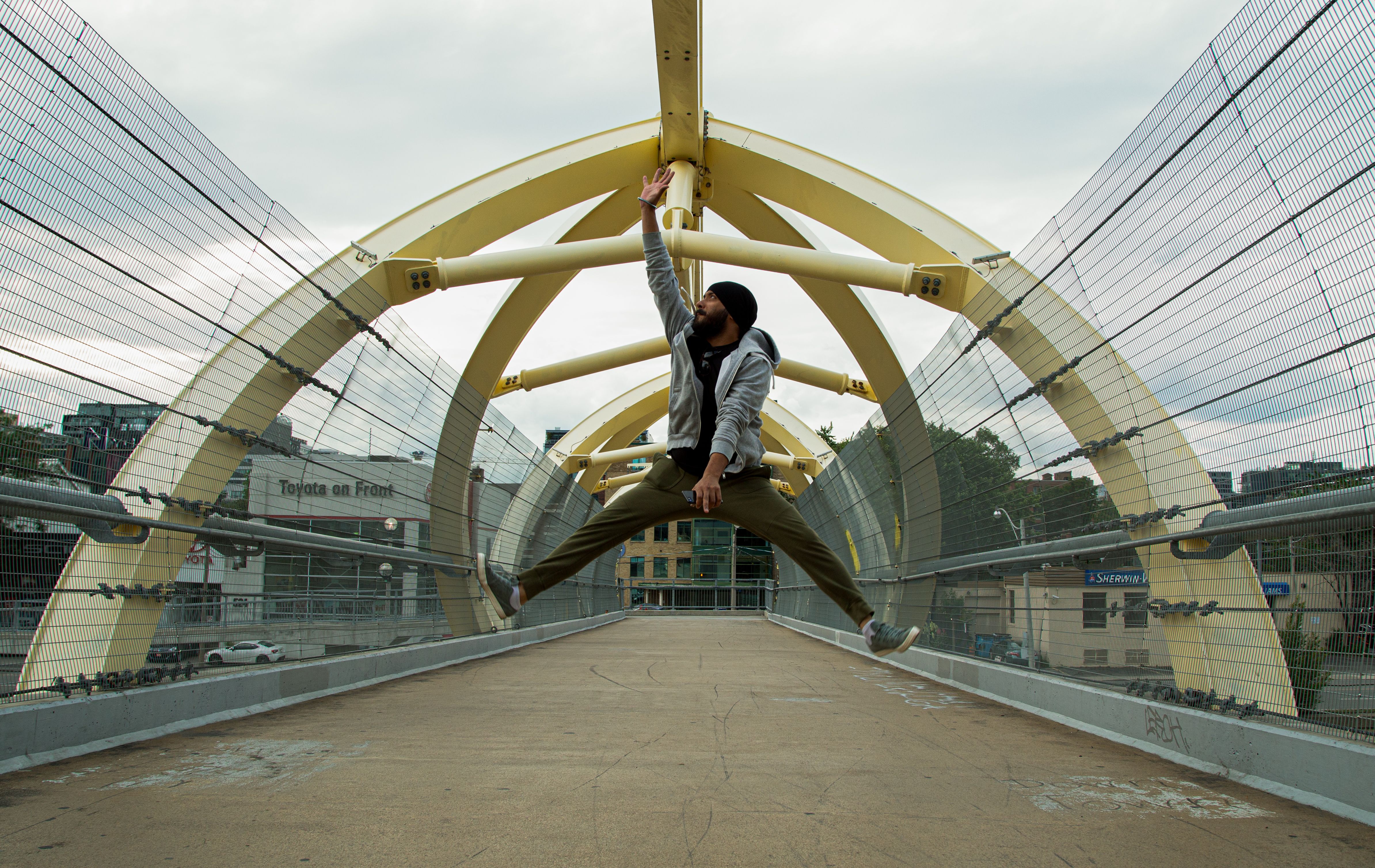 Man Jumping on Footbridge in City · Free Stock Photo